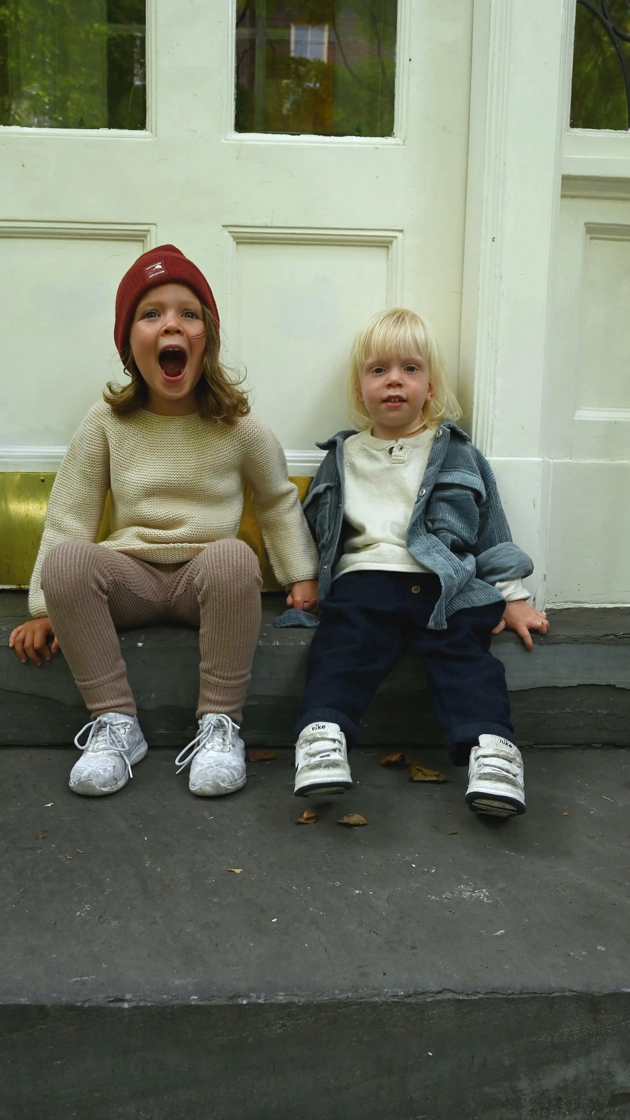 Children Sitting on Doorstep Looking at Camera · Free Stock Video