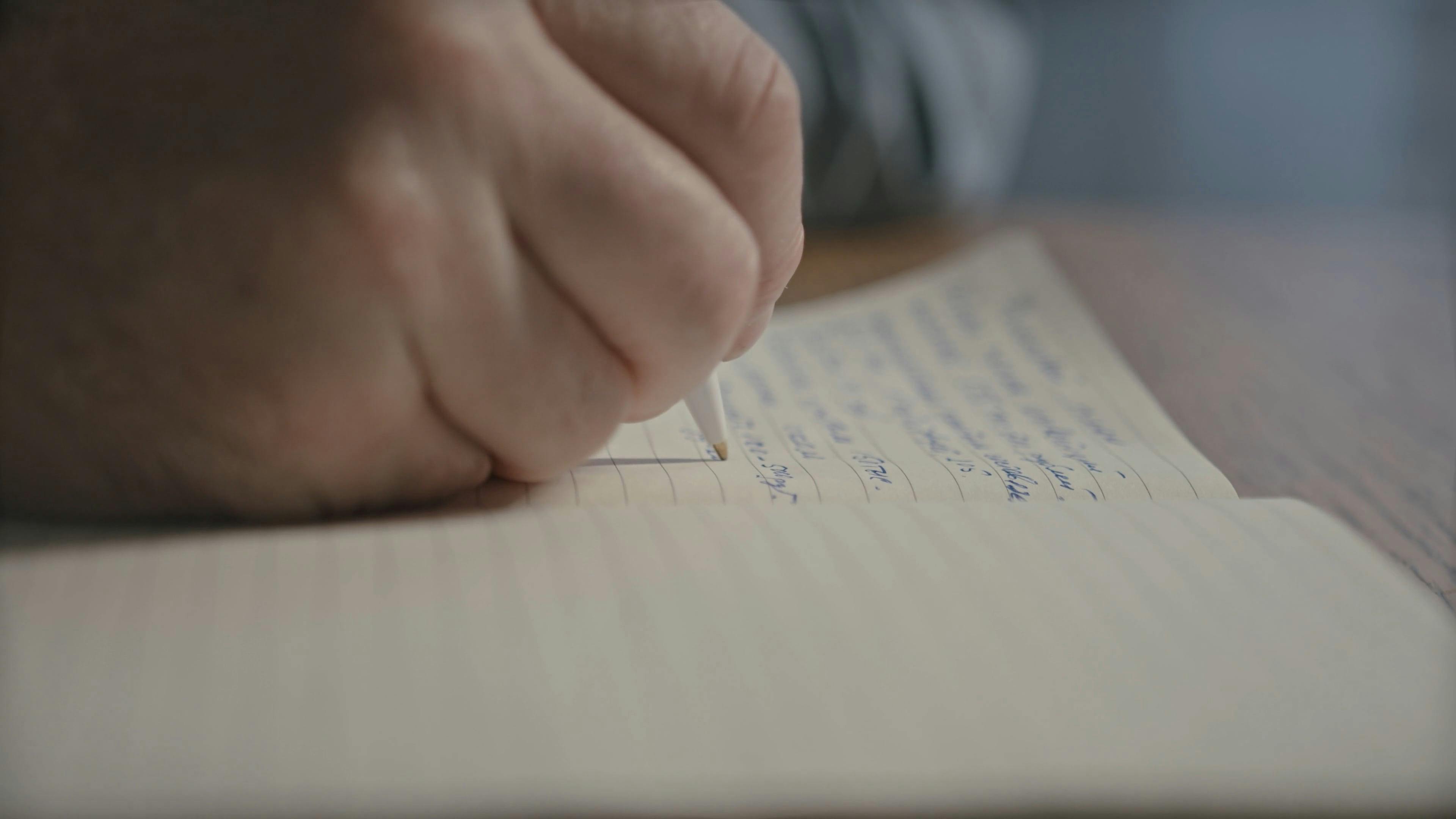 Back View Of Woman Writing In A Notebook · Free Stock Video