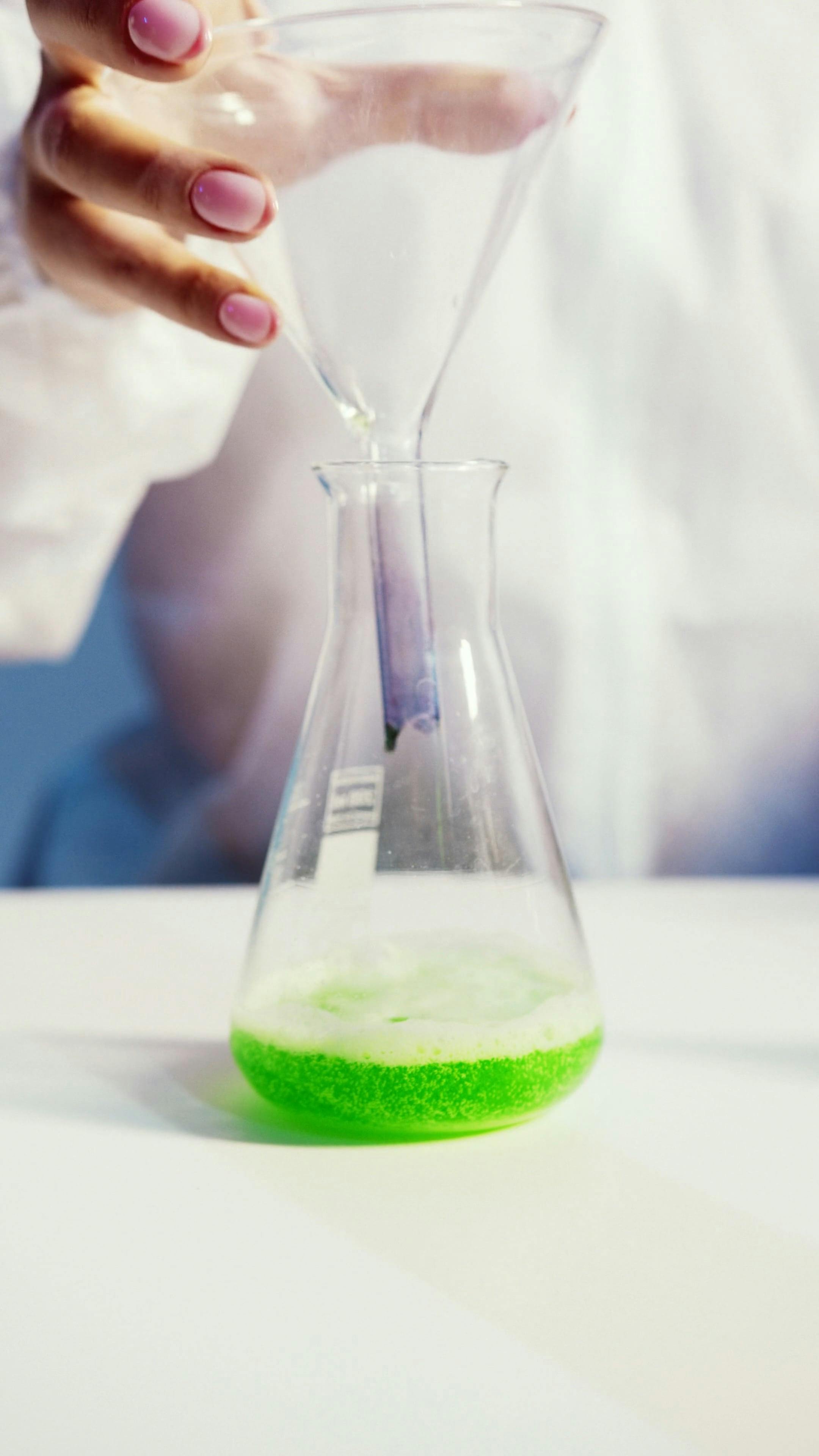 A Person Putting a Funnel on an Erlenmeyer Flask · Free Stock Video