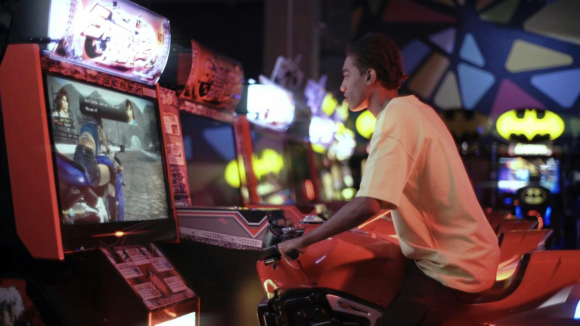 Side View of Young Guy Playing Bike Arcade Game · Free Stock Video