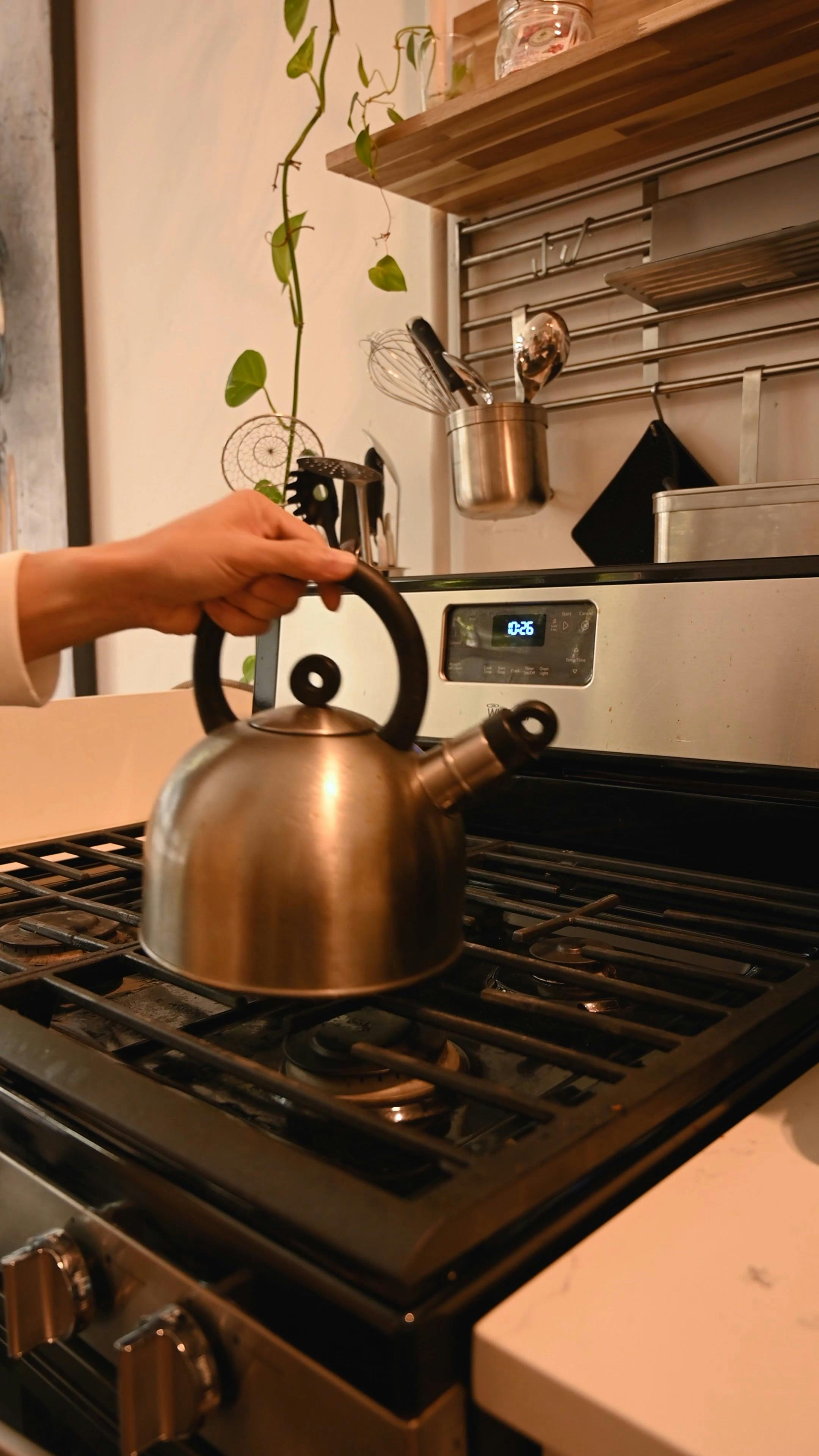 Person Heating Water with a Kettle · Free Stock Video