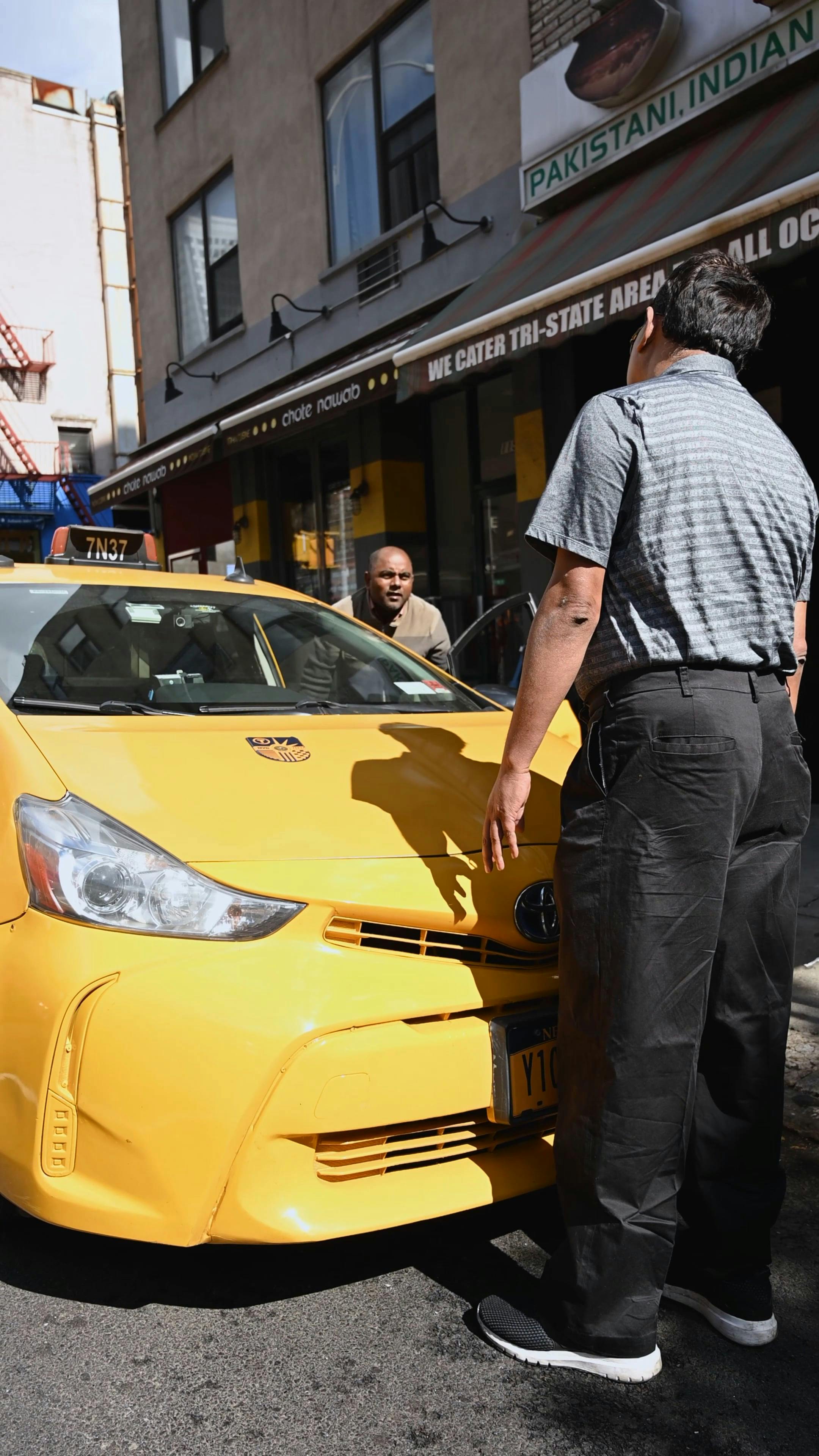 Cab Driver Read Newspaper Standing by his Car · Free Stock Video
