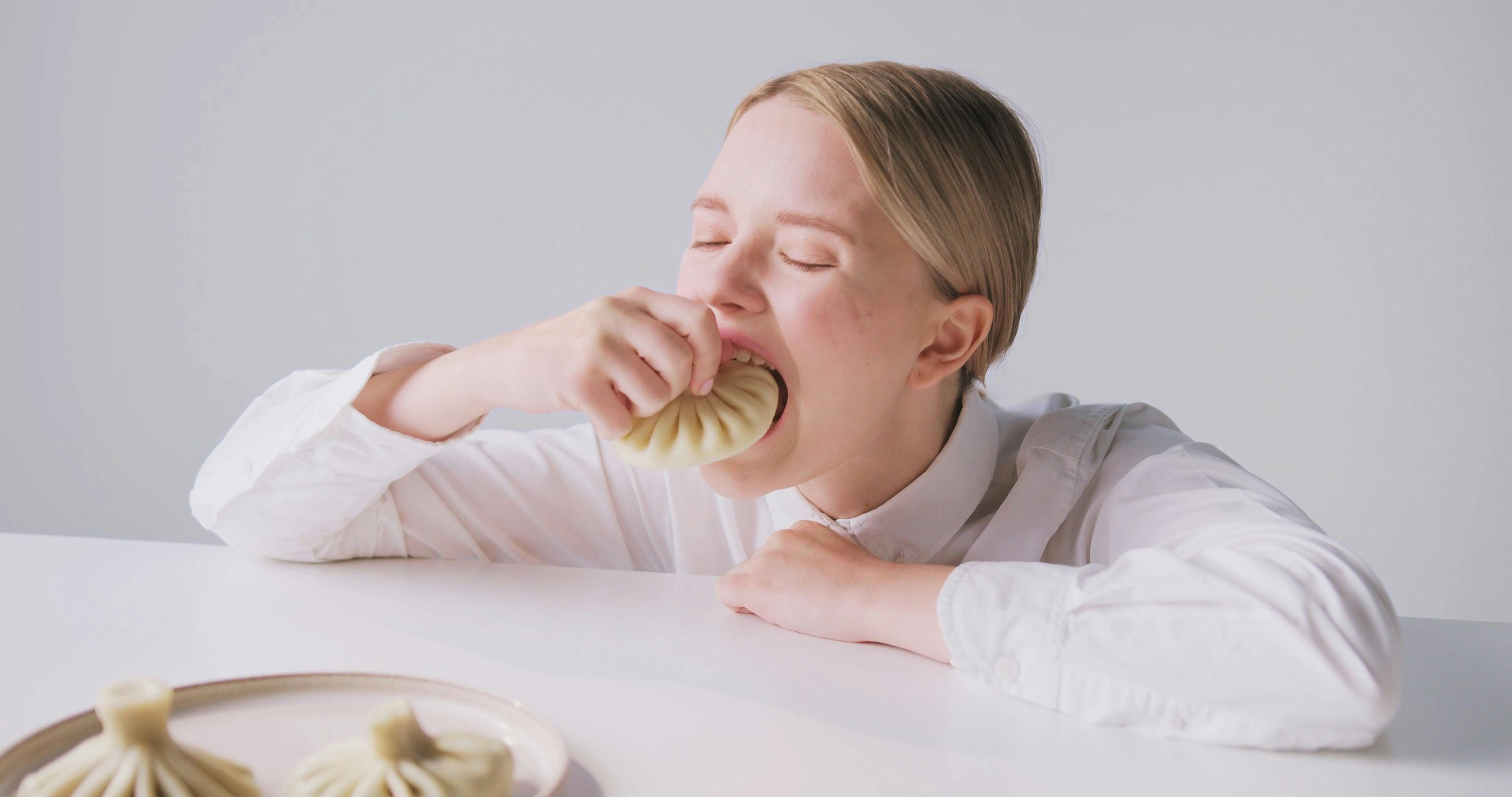 A Person Eating Dumpling while Looking in the Camera Free Stock Video ...