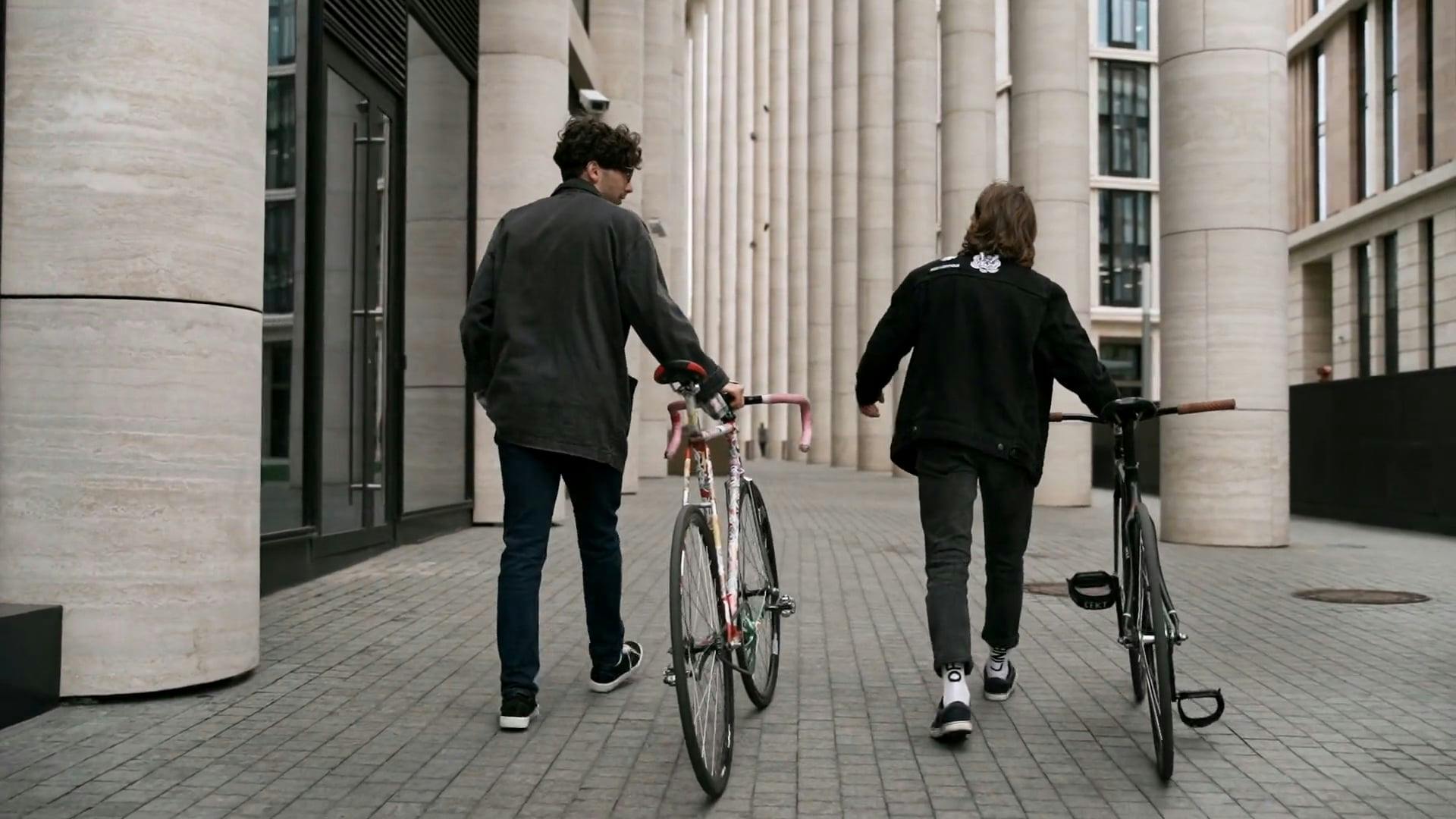 Back View of Two Young Men Walking with Bicycles · Free Stock Video