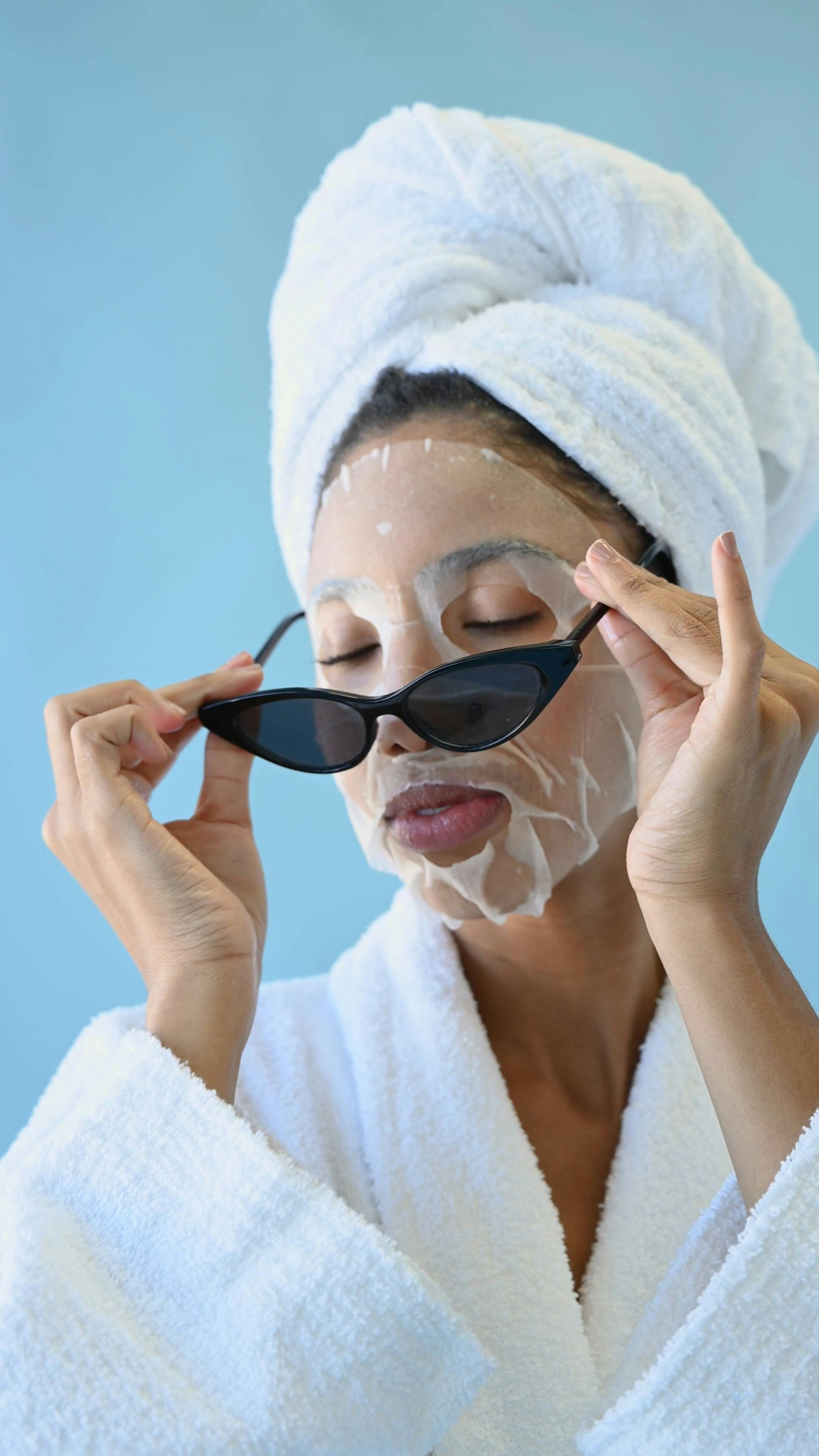 A Woman Putting on Sun Glasses while Wearing a Sheet Mask · Free Stock ...
