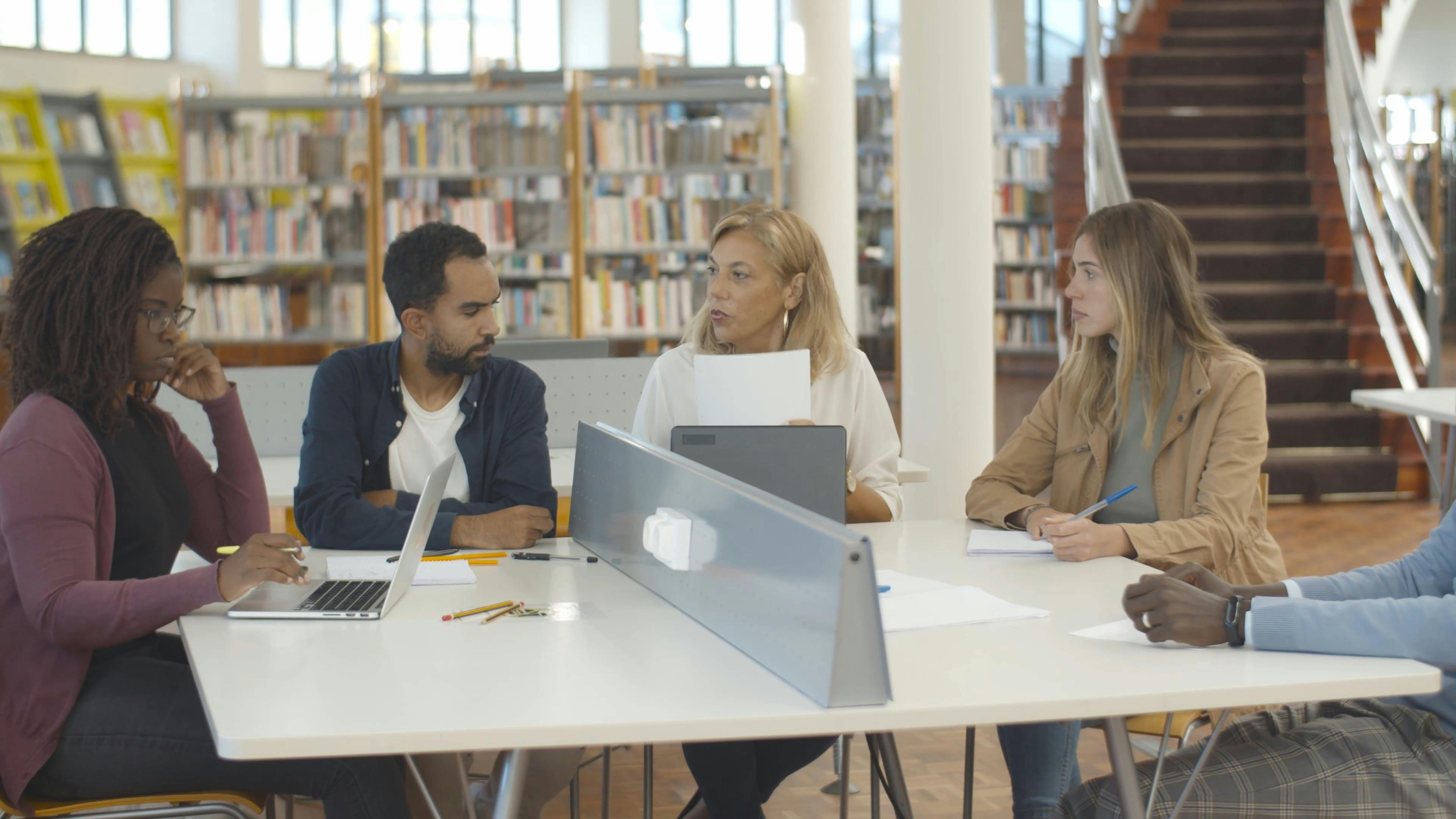 Teacher Giving Sheets to Students in a Library Free Stock Video Footage ...