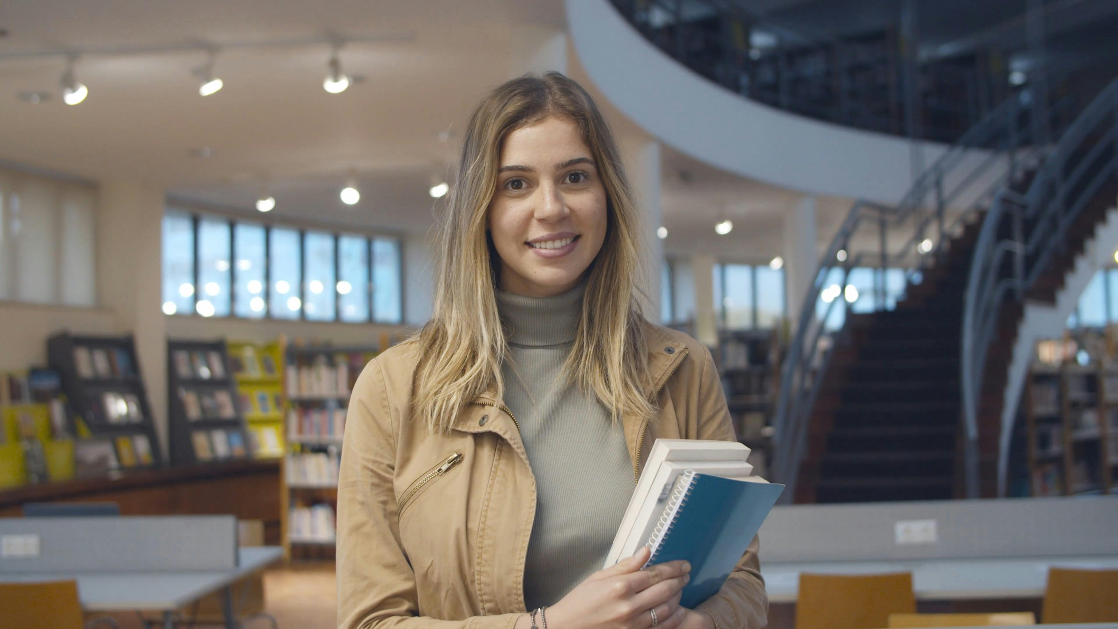 Woman Holding Books Inside a Library · Free Stock Video