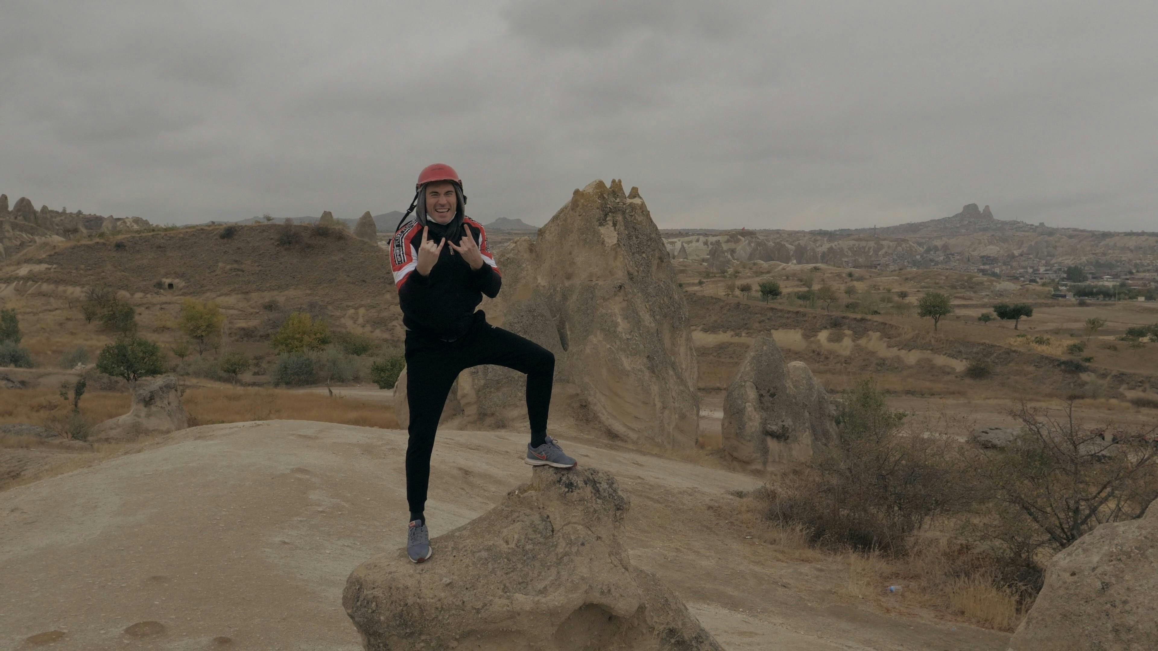 A Man Posing in the Camera while on Top of the Rock · Free Stock Video