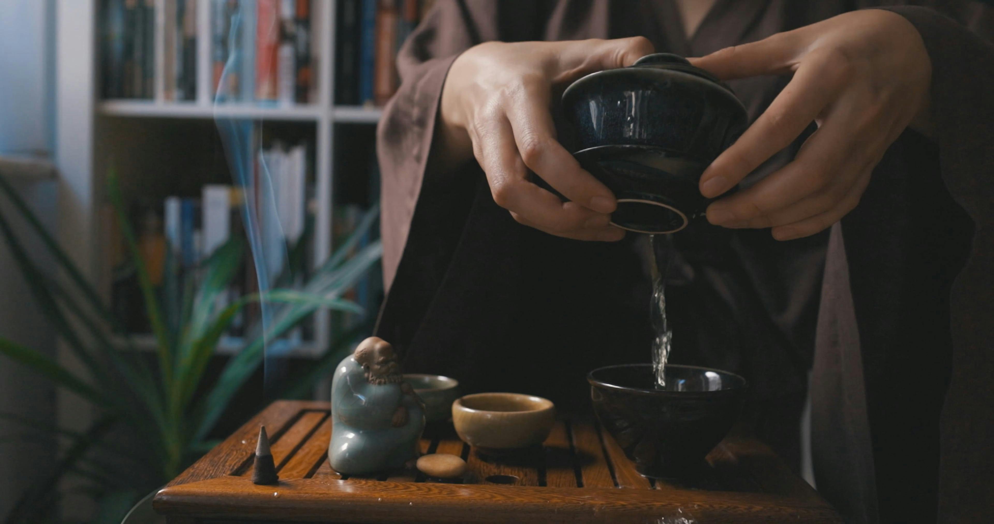 A Woman Spilling Some of the Tea that She is Pouring onto a Bowl Free ...
