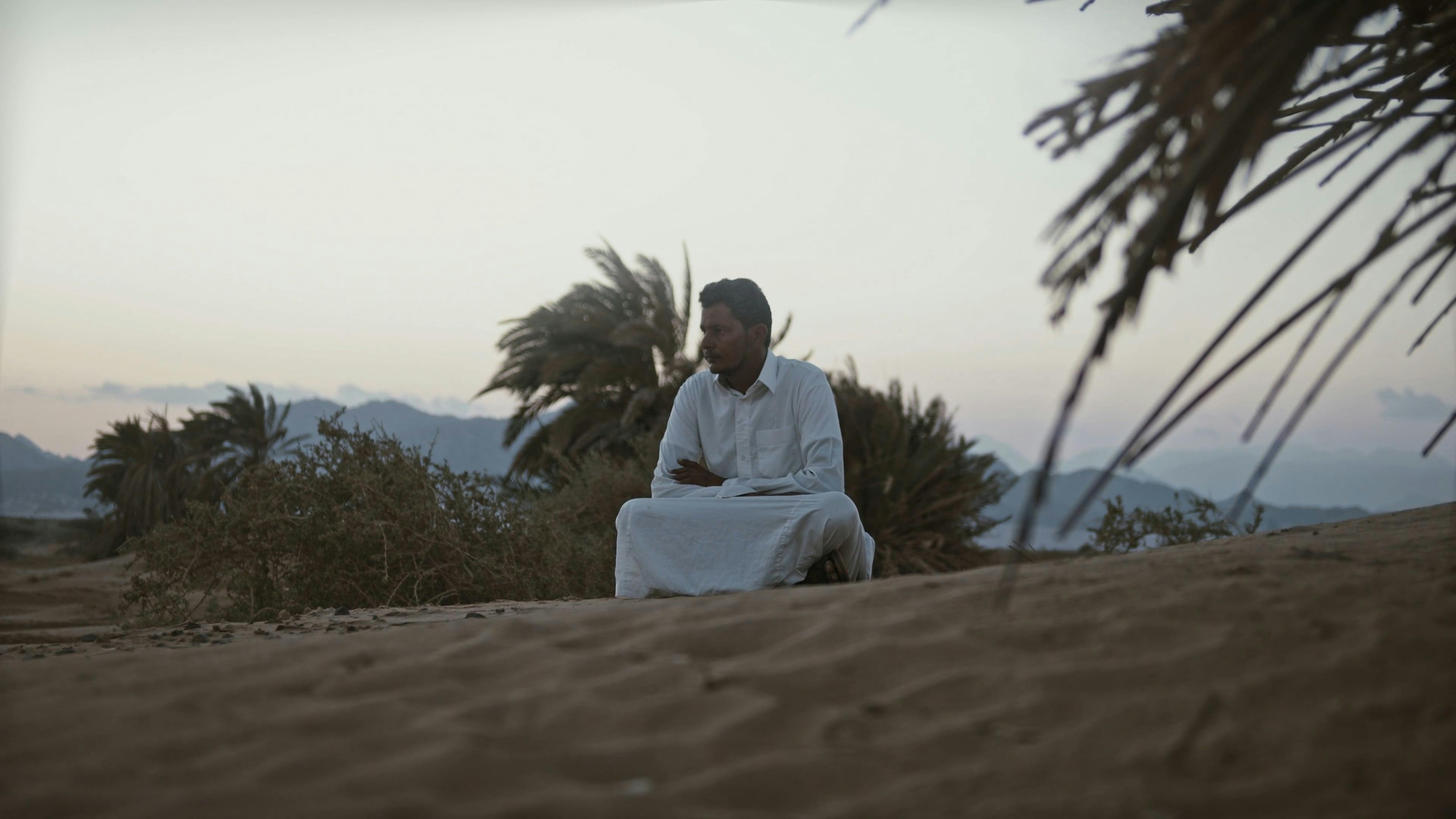 A Man Looking Away While Sitting in the Desert Free Stock Video Footage ...