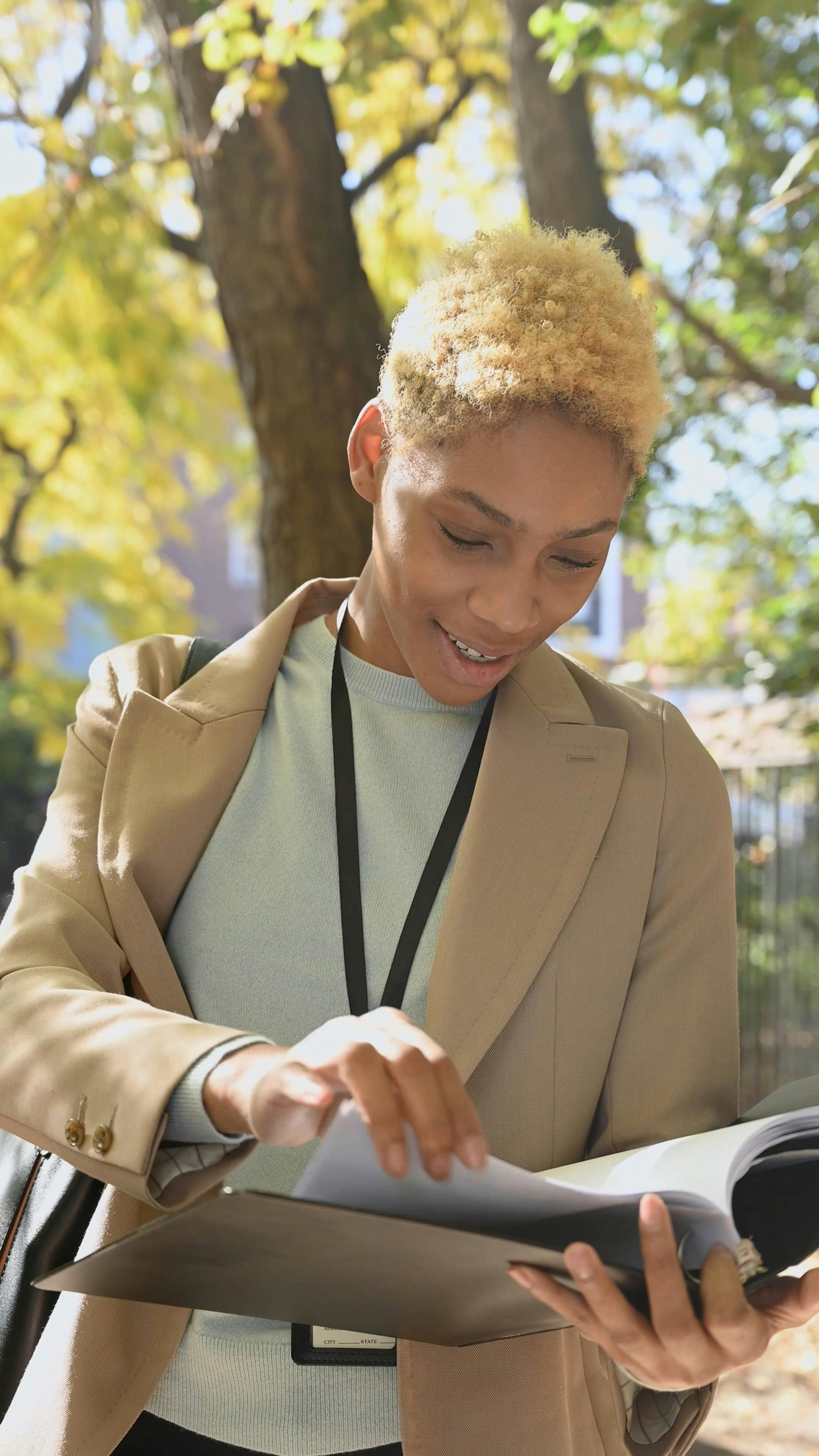 A Woman Reading Her Notes While Standing Near a Blue Wall · Free Stock ...