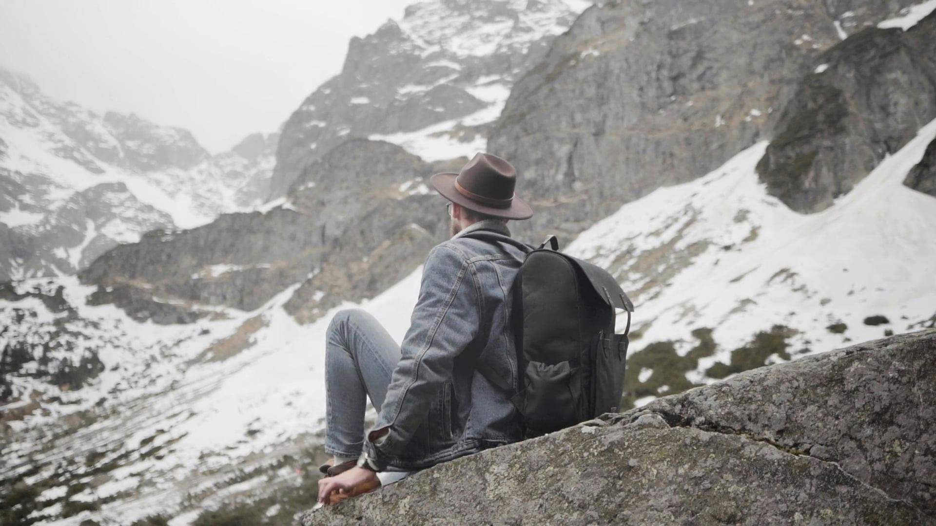 Back View of A Man Sitting on the edge of the Mountain · Free Stock Video