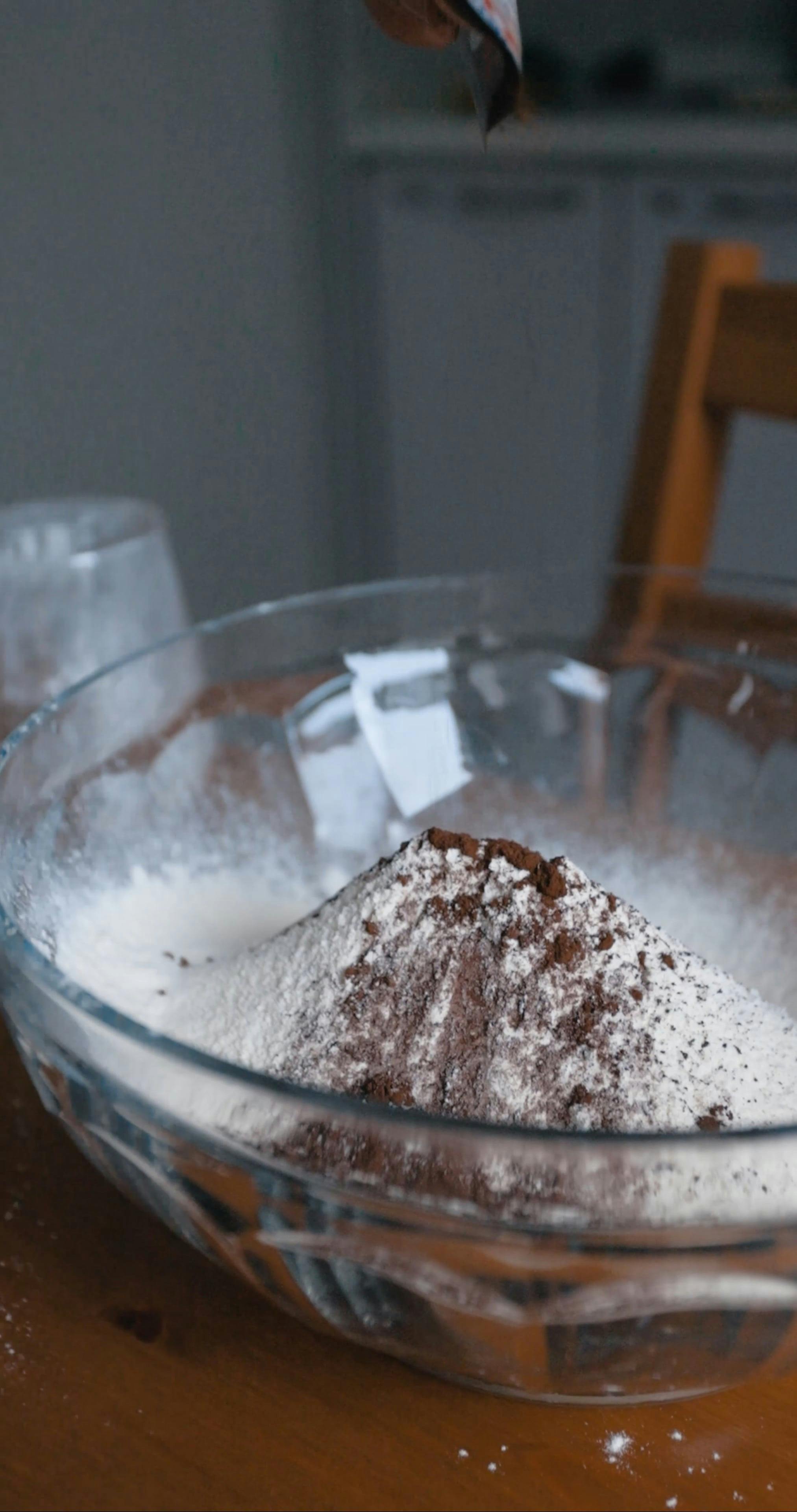 Person Pouring cocoa Powder on the Bowl with Flour · Free Stock Video