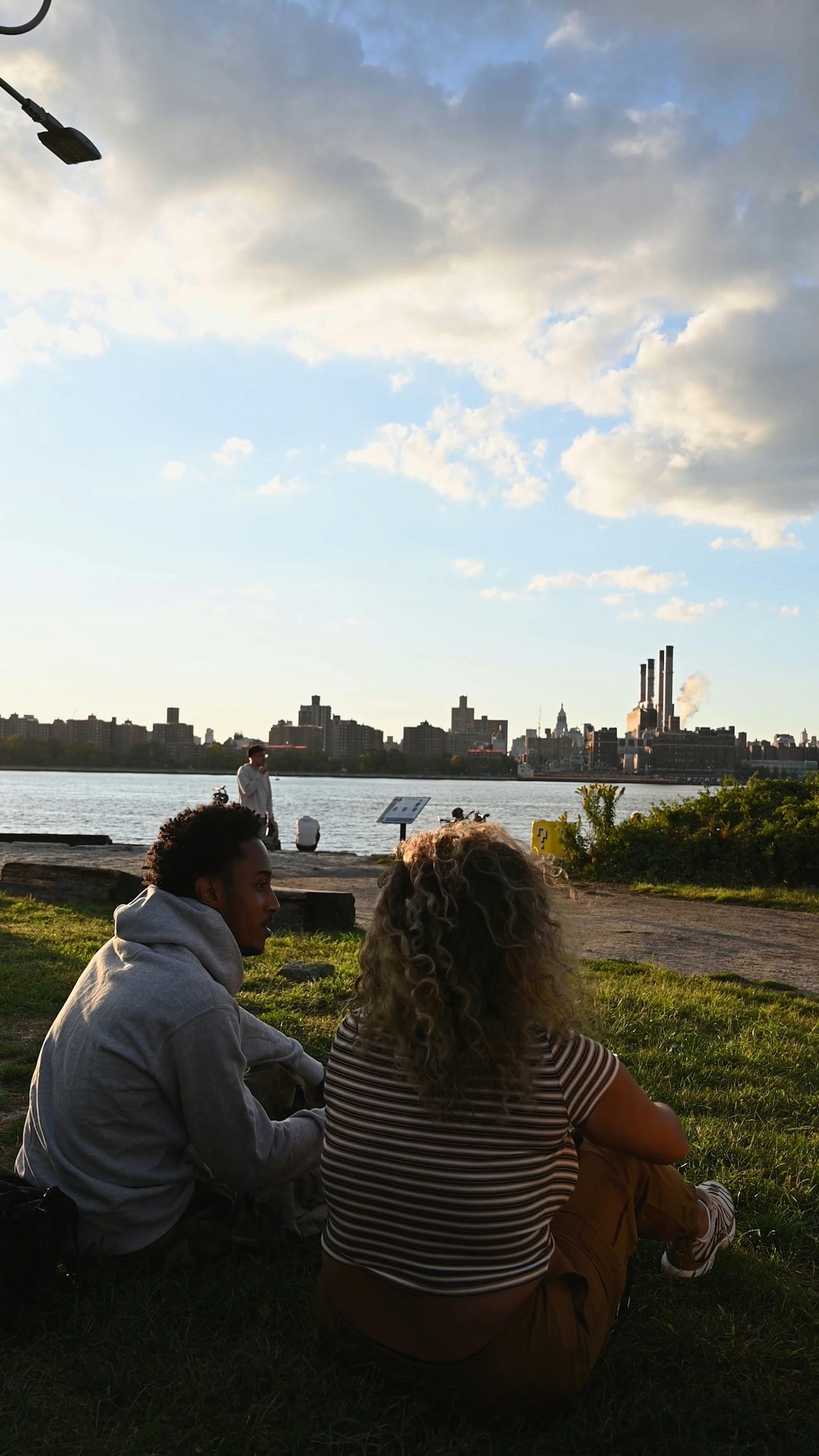 Back View of Friends Sitting and Chatting on City Shore · Free Stock Video