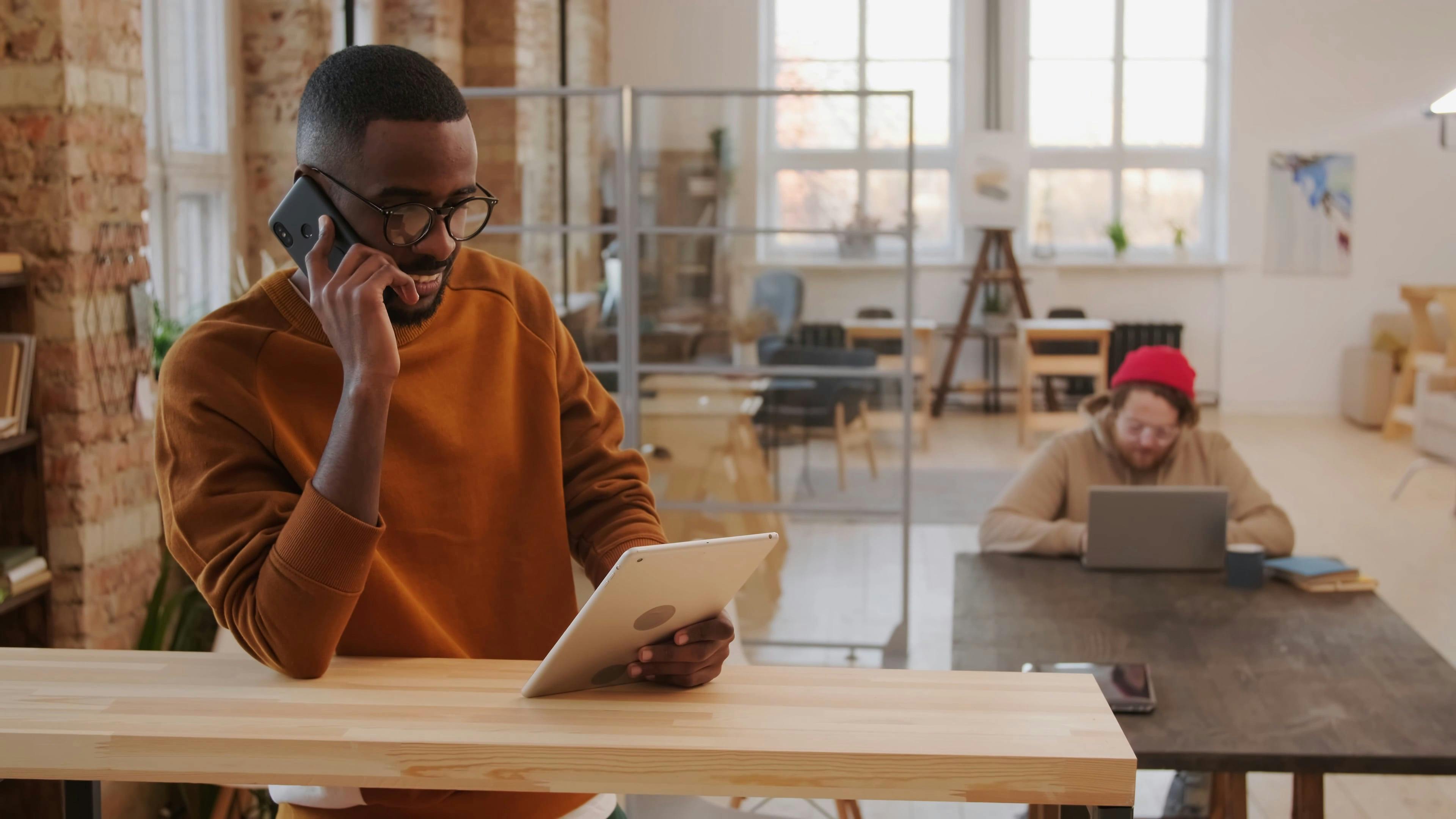 A Man Talking to Someone on the Phone While Holding a Tablet · Free ...