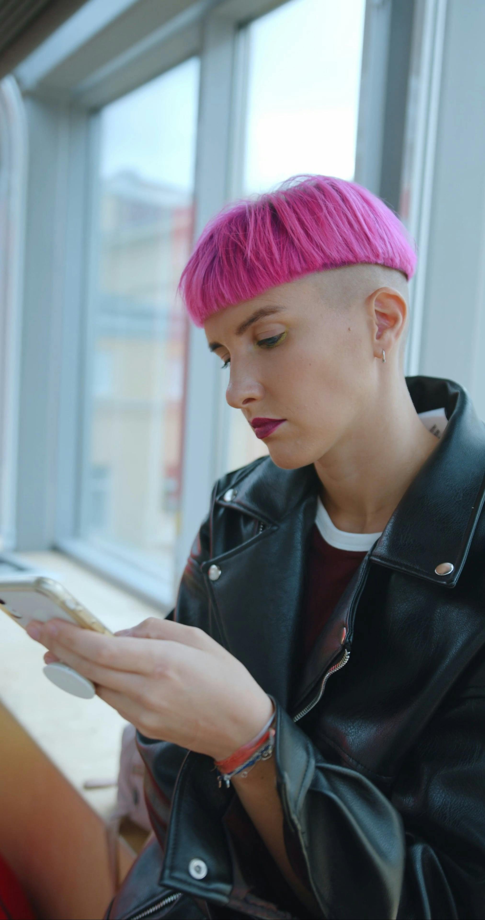 Young Woman Using Smartphone by Window · Free Stock Video
