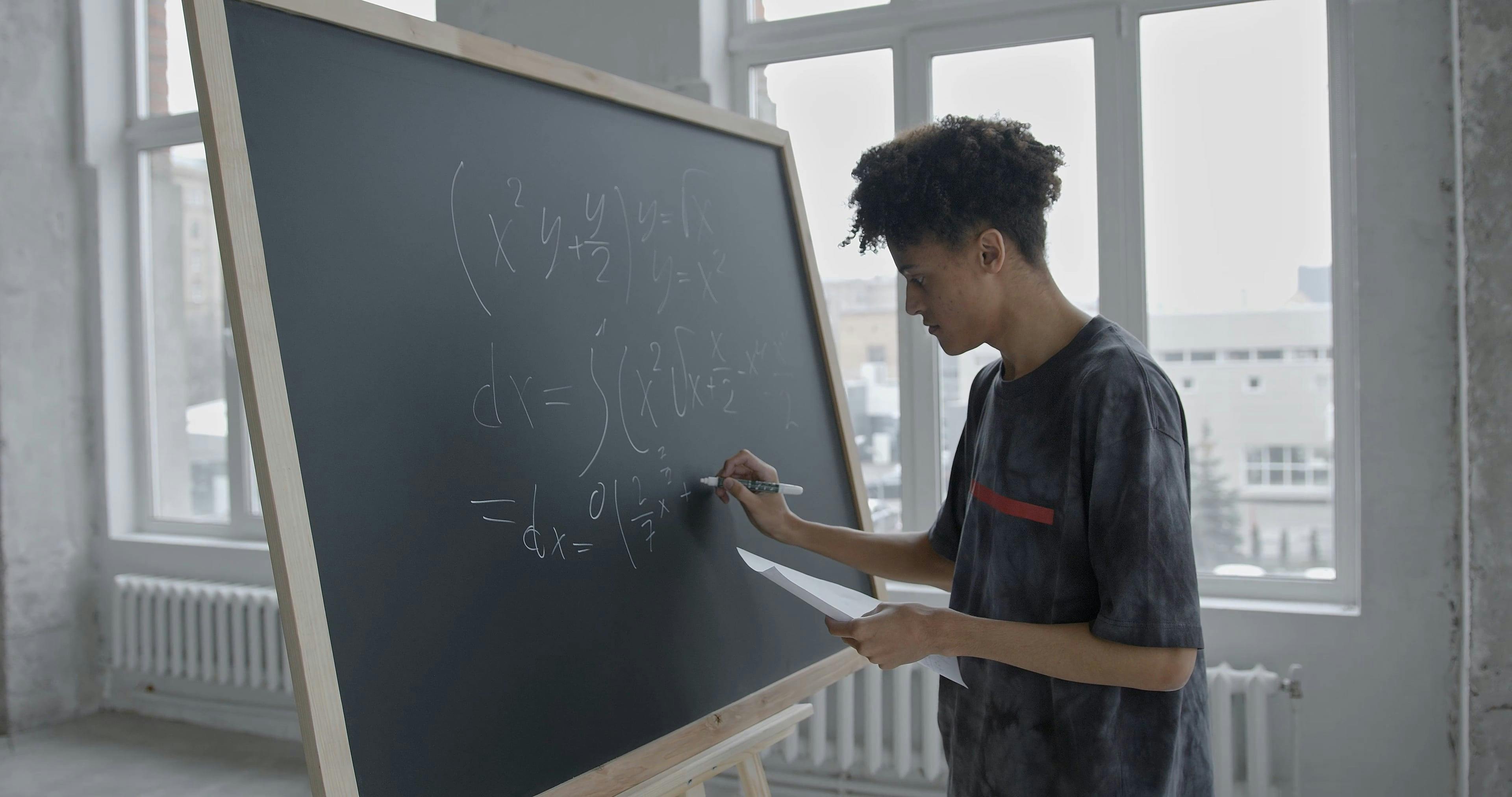 A Student Solving A Math Equation On The Blackboard · Free Stock Video