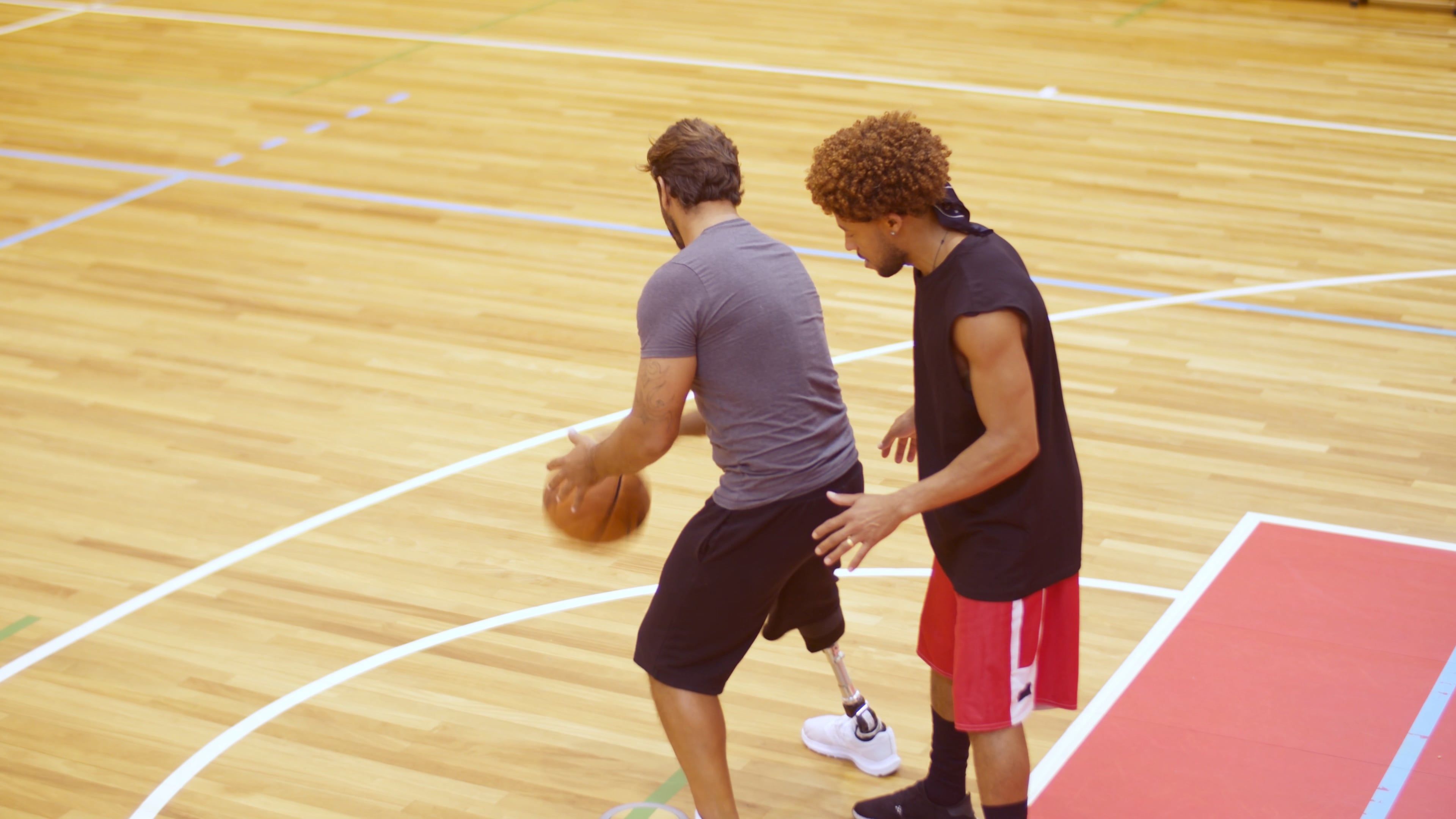 Man with Prosthetic Leg Grabbing Ball in Basketball Court Free Stock ...