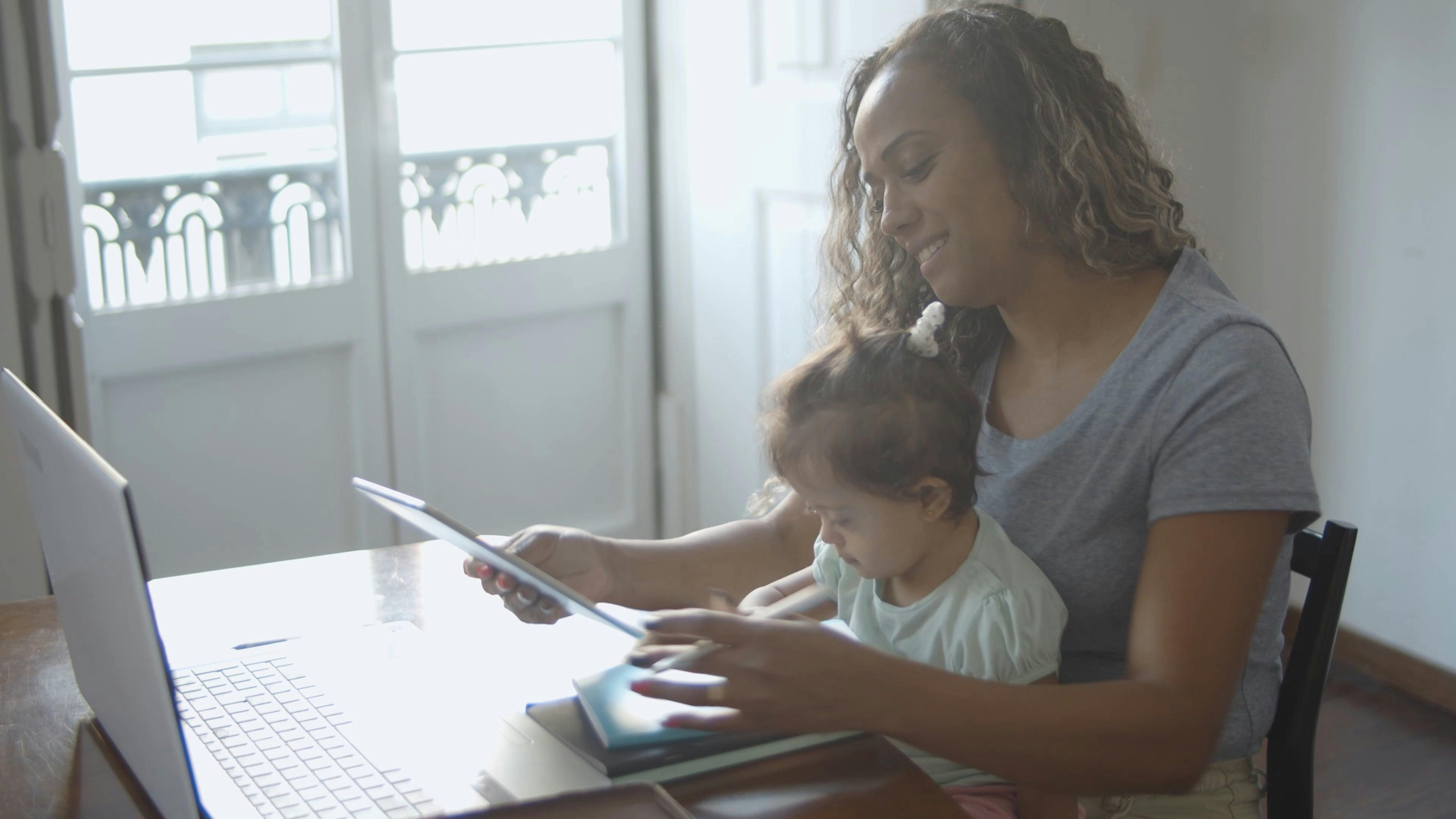 Woman Working While Holding Her Daughter · Free Stock Video
