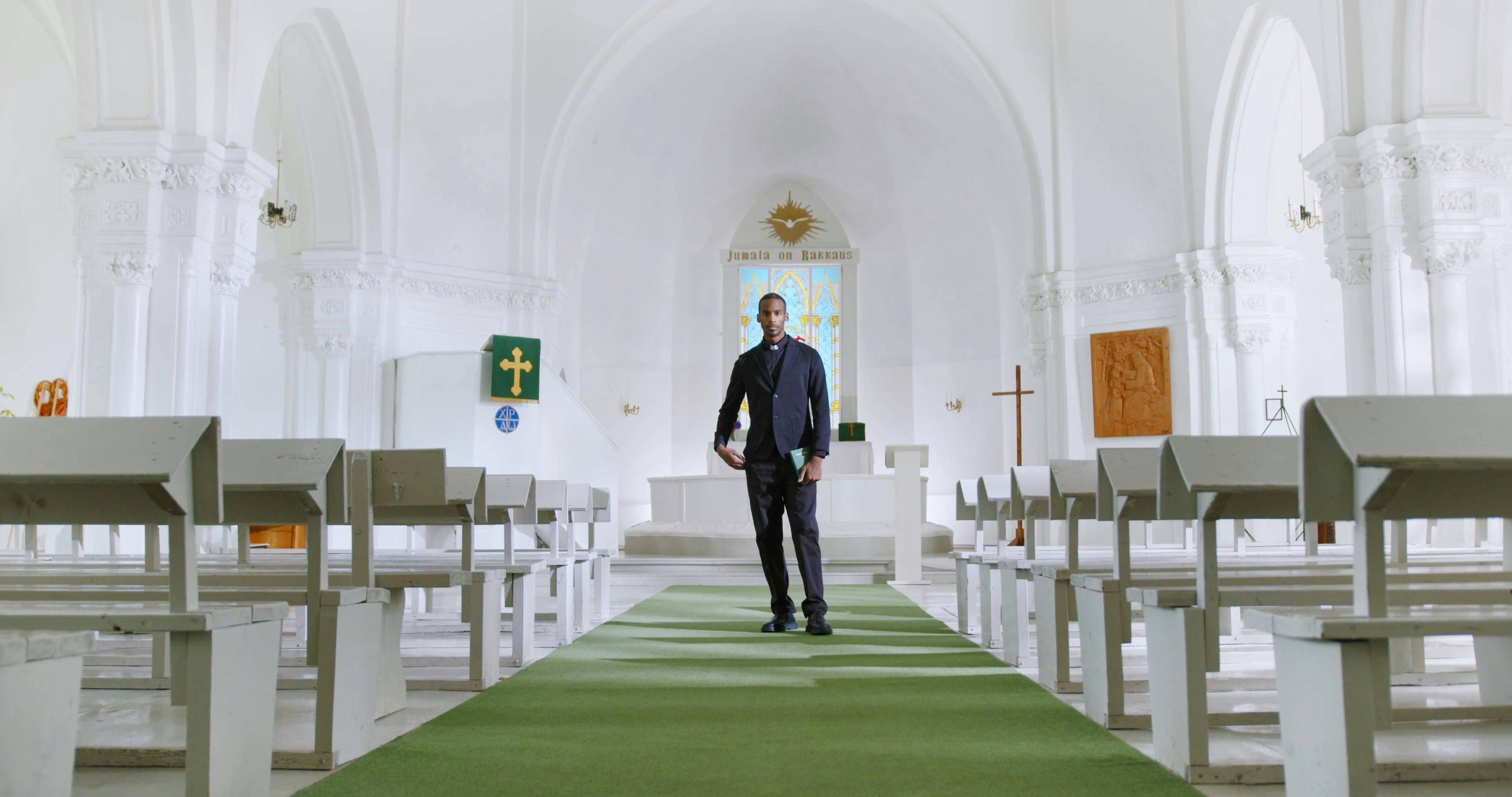Priest Standing at the Center of the Church Holding a Bible · Free ...