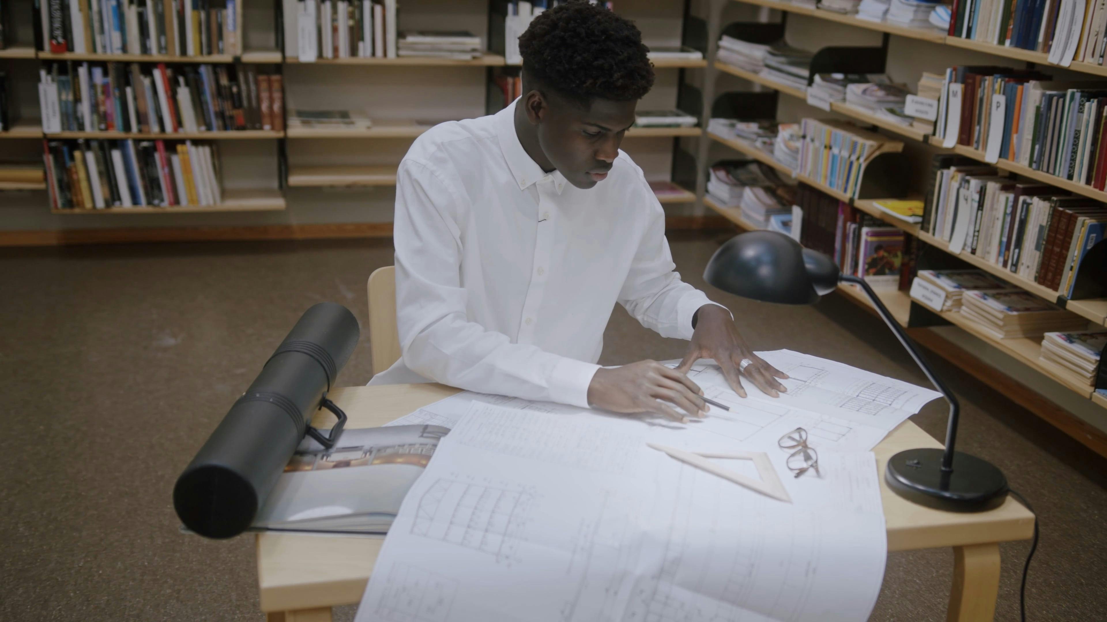 Young Male Student Doing Homework in Library · Free Stock Video