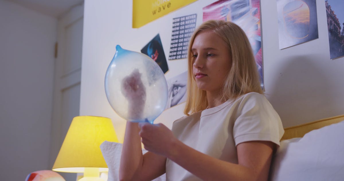 Young Woman Playing With Condom Balloon Free Stock Video Footage