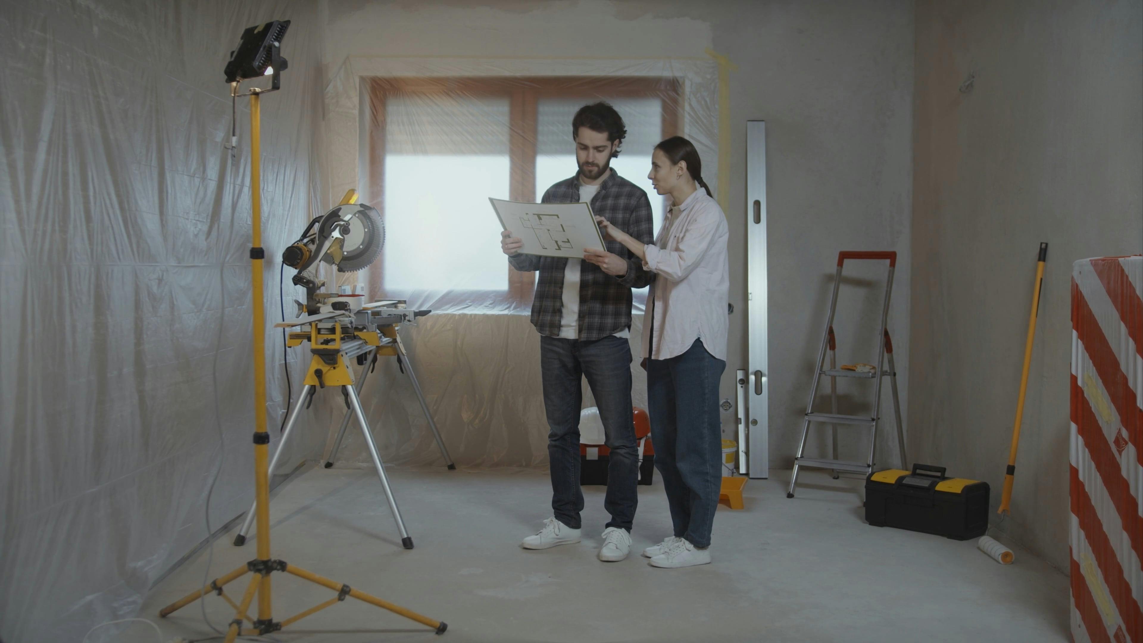 Man and Woman Talking about Home Renovation with Blueprint in Hand Free ...
