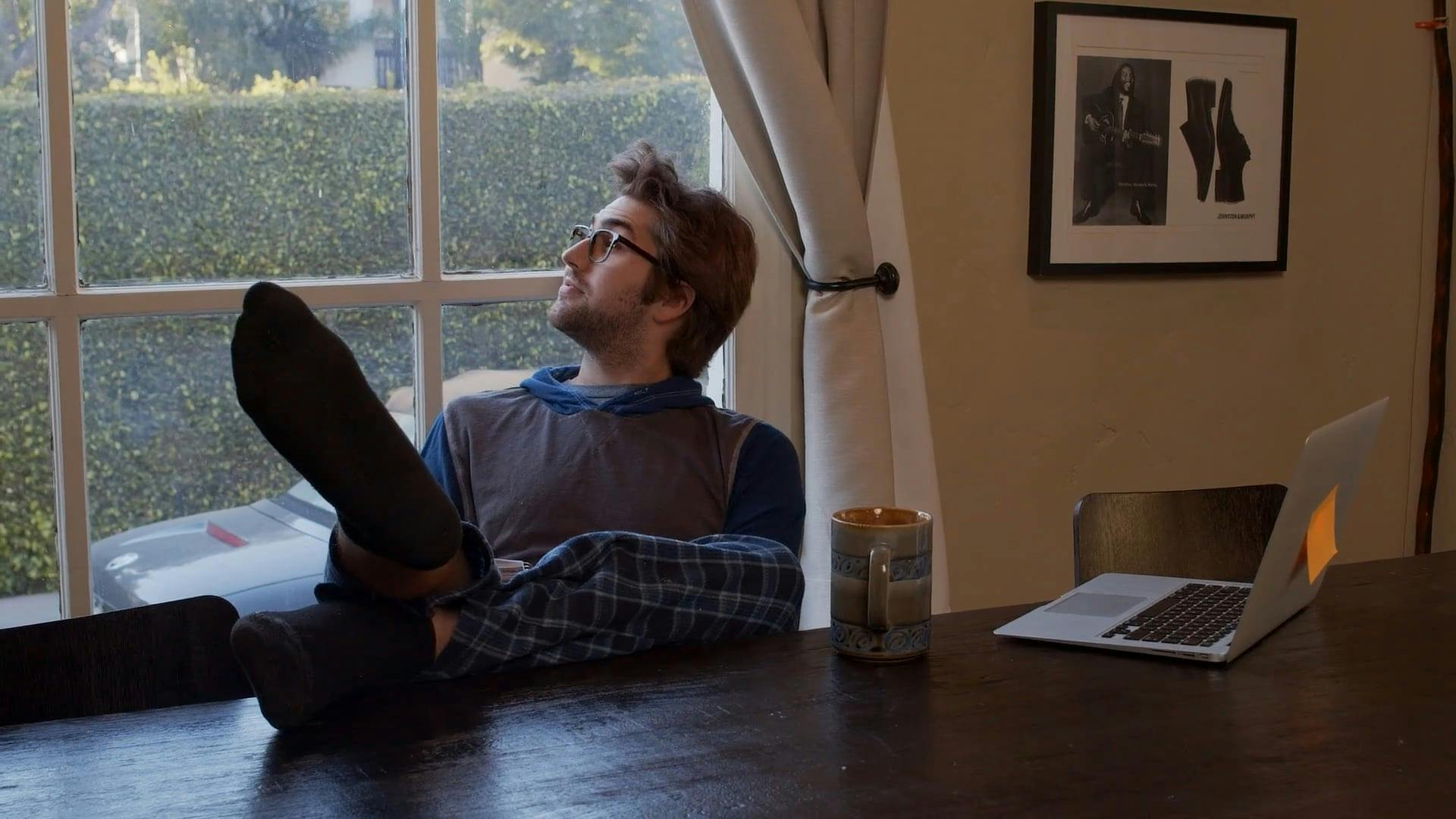 A Man Drinking While Writing on the Notebook and Typing on the Laptop ...