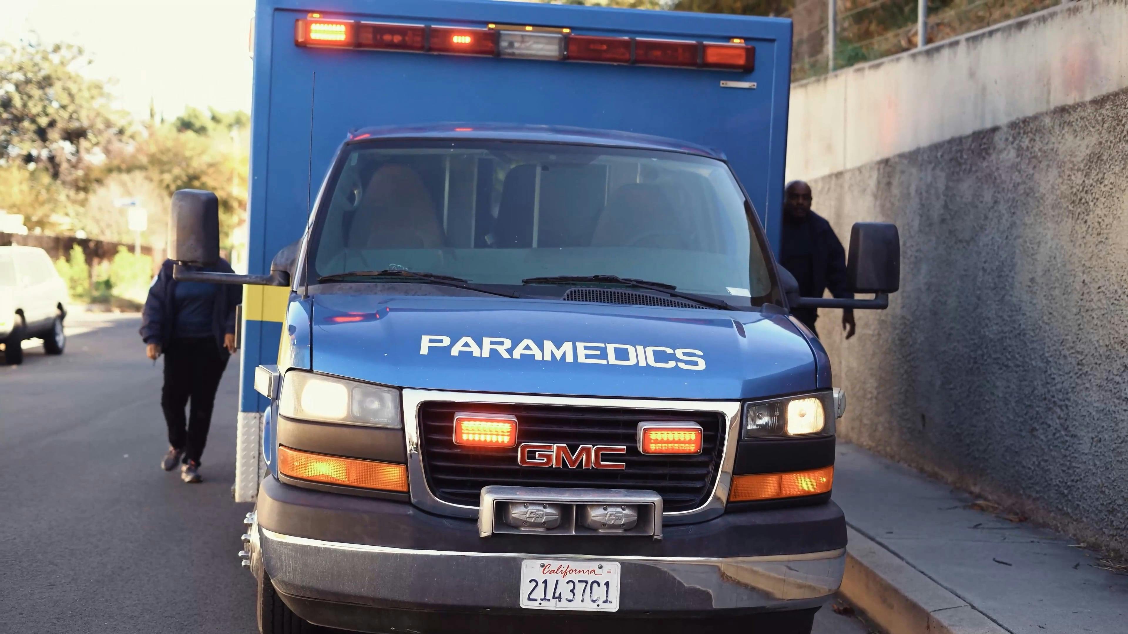 An Ambulance Parked On A Street With Emergency Flashers On Free Stock ...