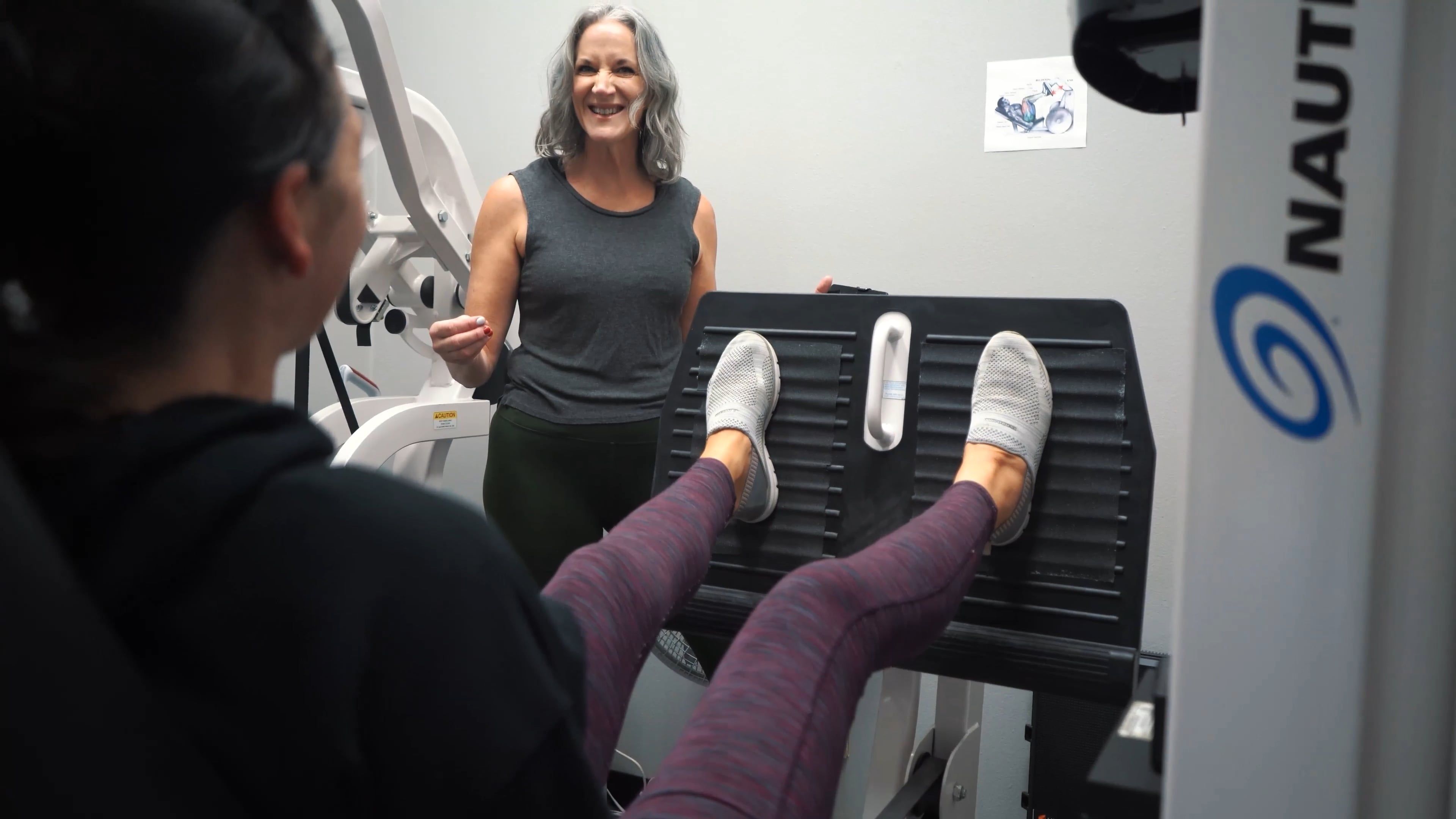 A woman is sitting on a machine in a gym Free Stock Video Footage ...