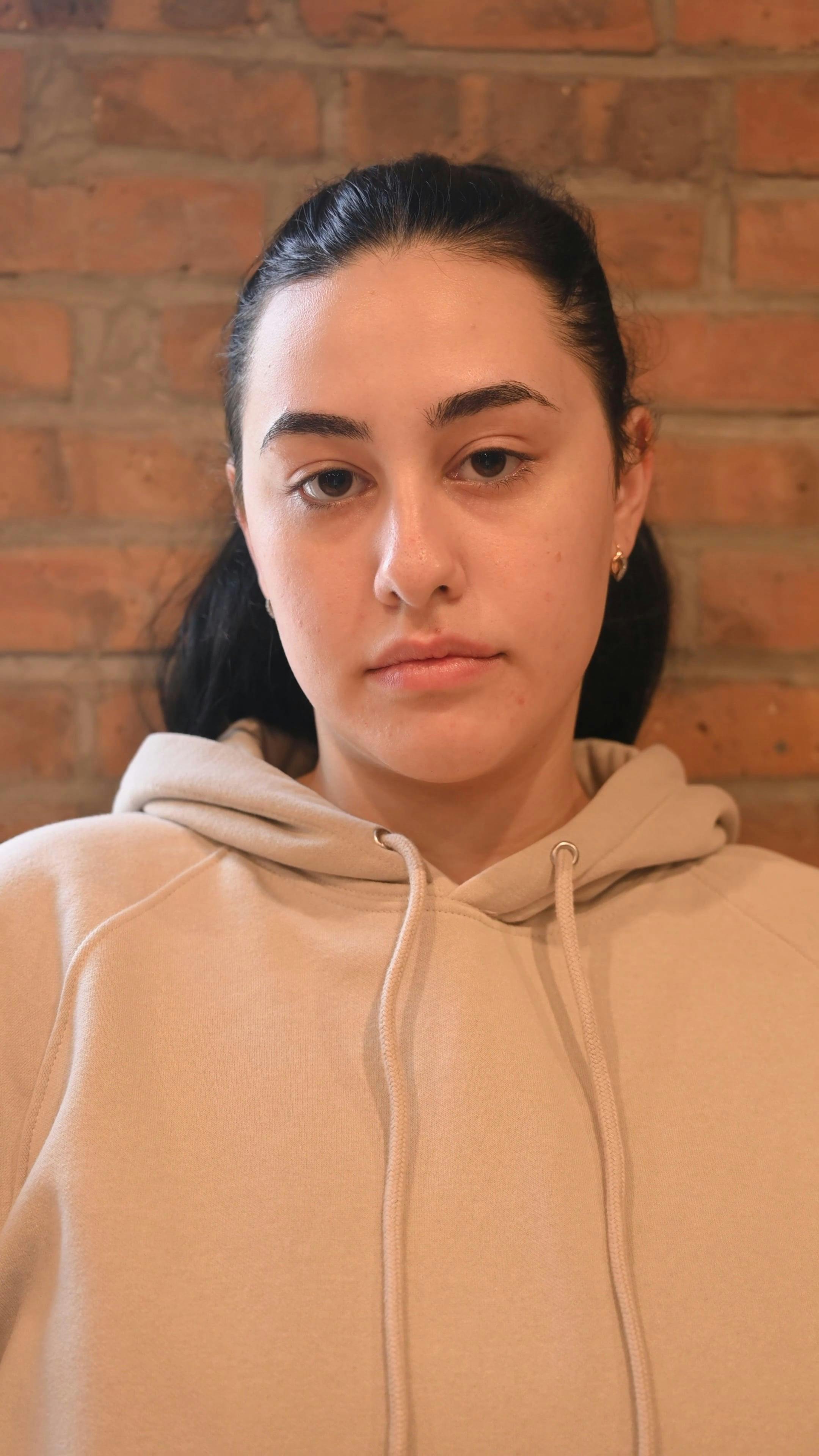 A Woman Staring at the Camera Behind a Brick Wall Free Stock Video ...