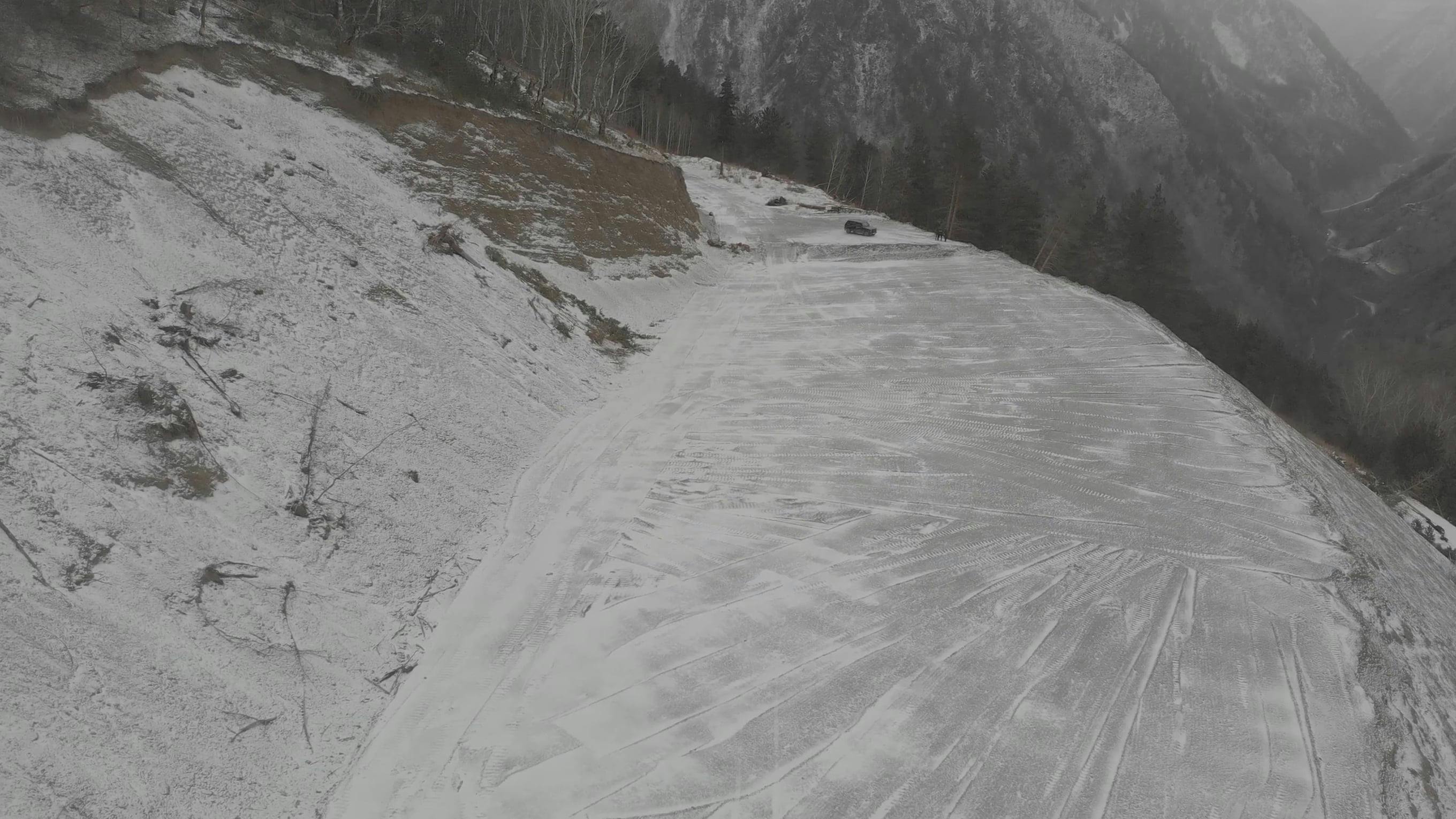 Aerial View of the Snow Covered Road on a Mountain Side · Free Stock Video