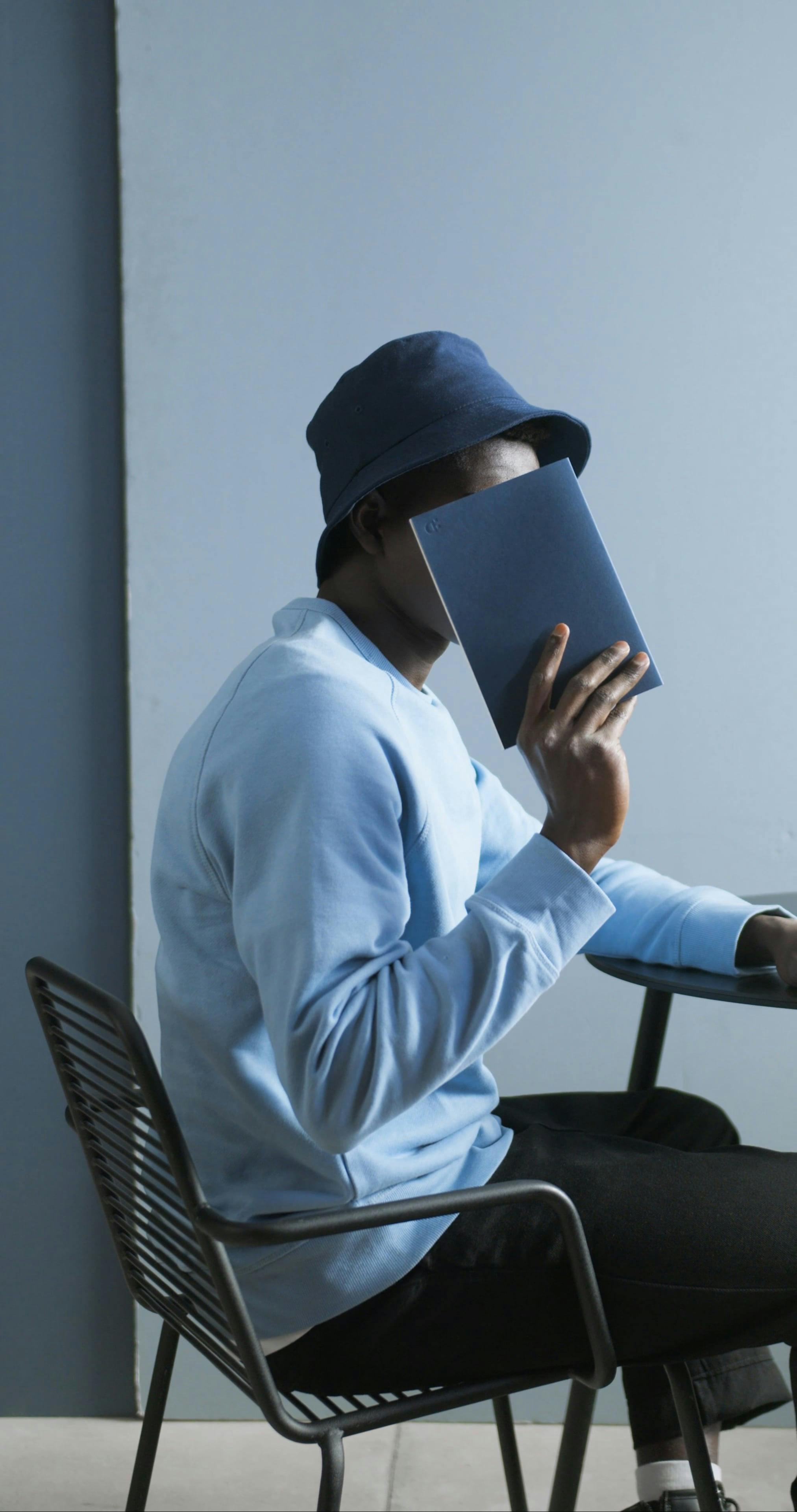 Man Covering Face with Notebook · Free Stock Video