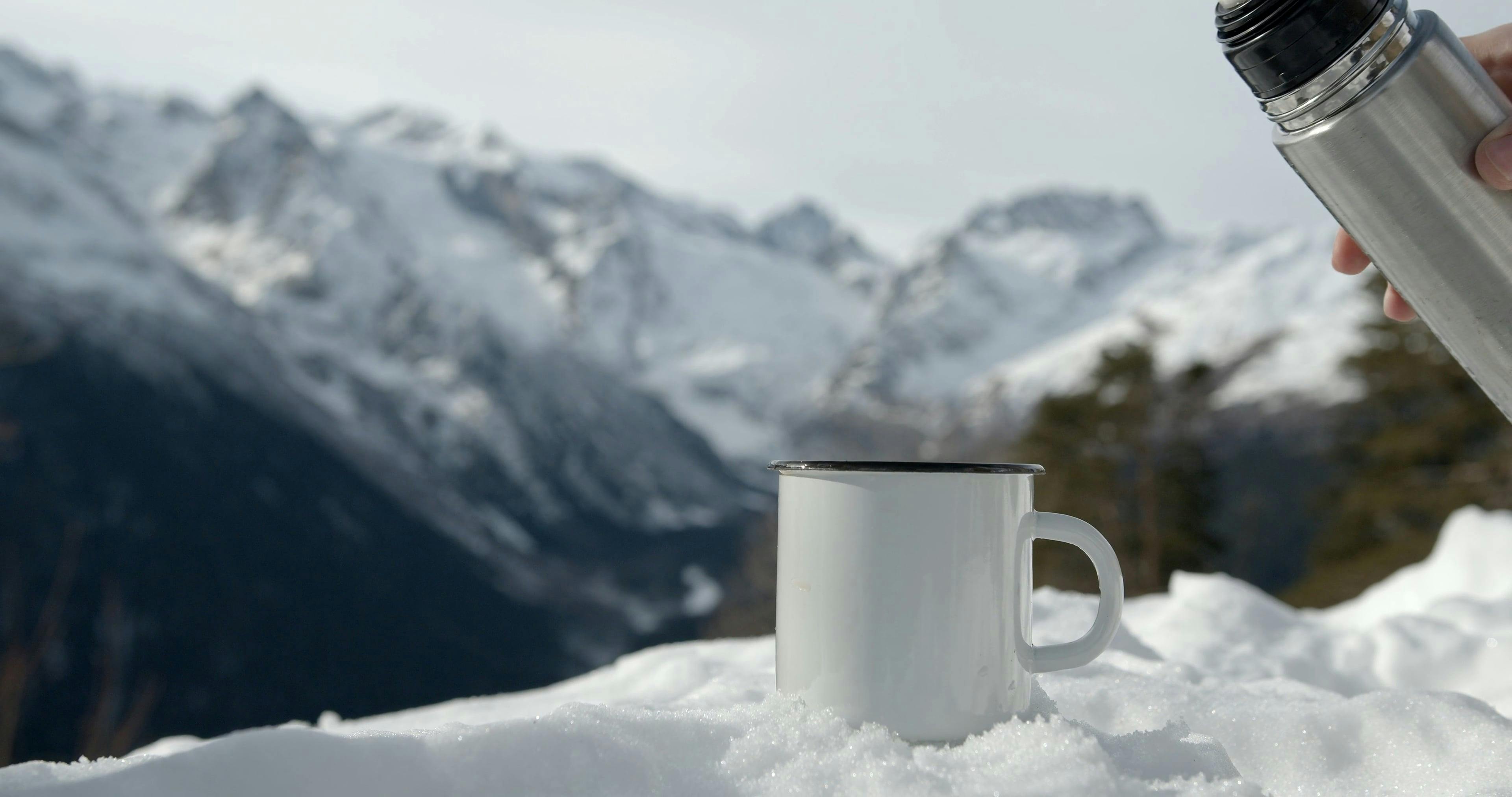 A Person Pouring Coffee into a Mug in the Snow · Free Stock Video