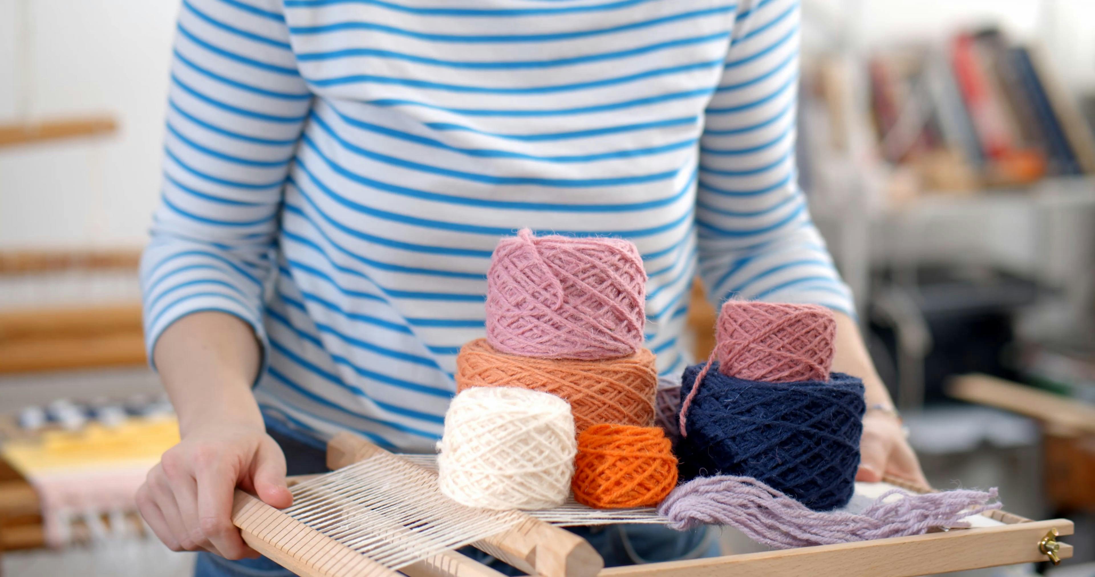 Woman Holding Small Weaving Loom and Balls of Yarn · Free Stock Video