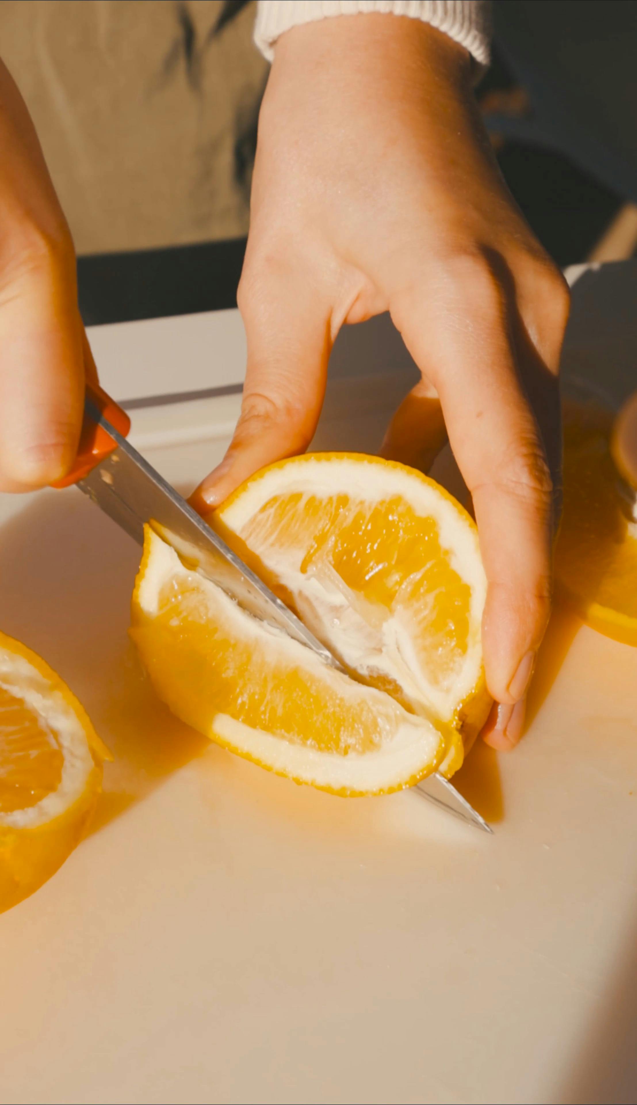 Person Slicing Oranges on a Chopping Board · Free Stock Video