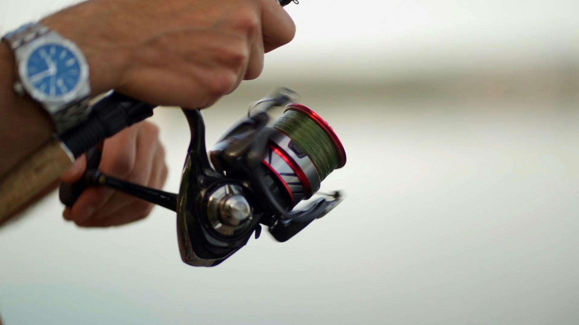 Close-up Footage of a Person Spinning the Handle of the Fishing Rod ...