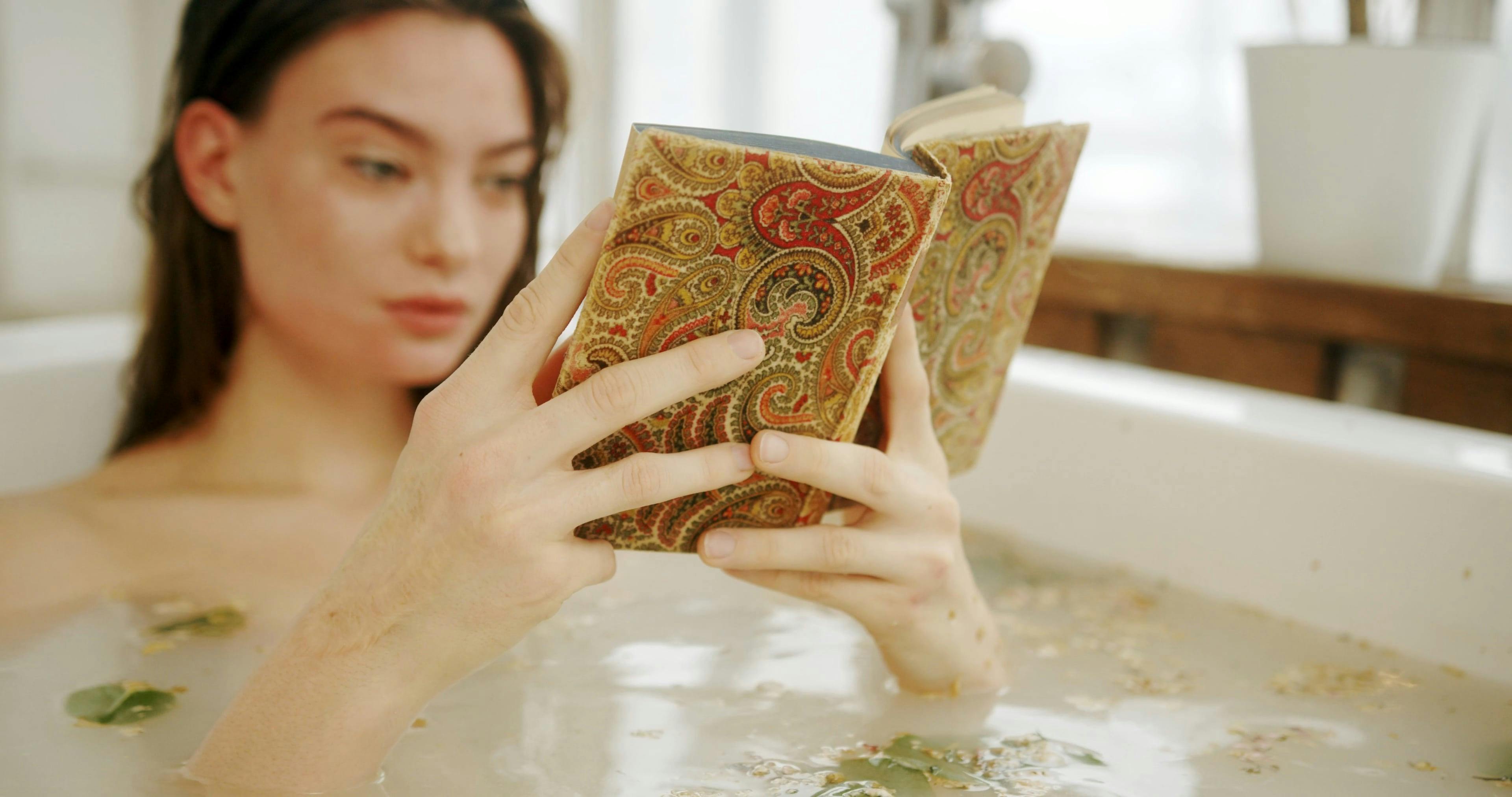 A Woman Reading a Book while Sitting in a Bath Tub Free Stock Video ...