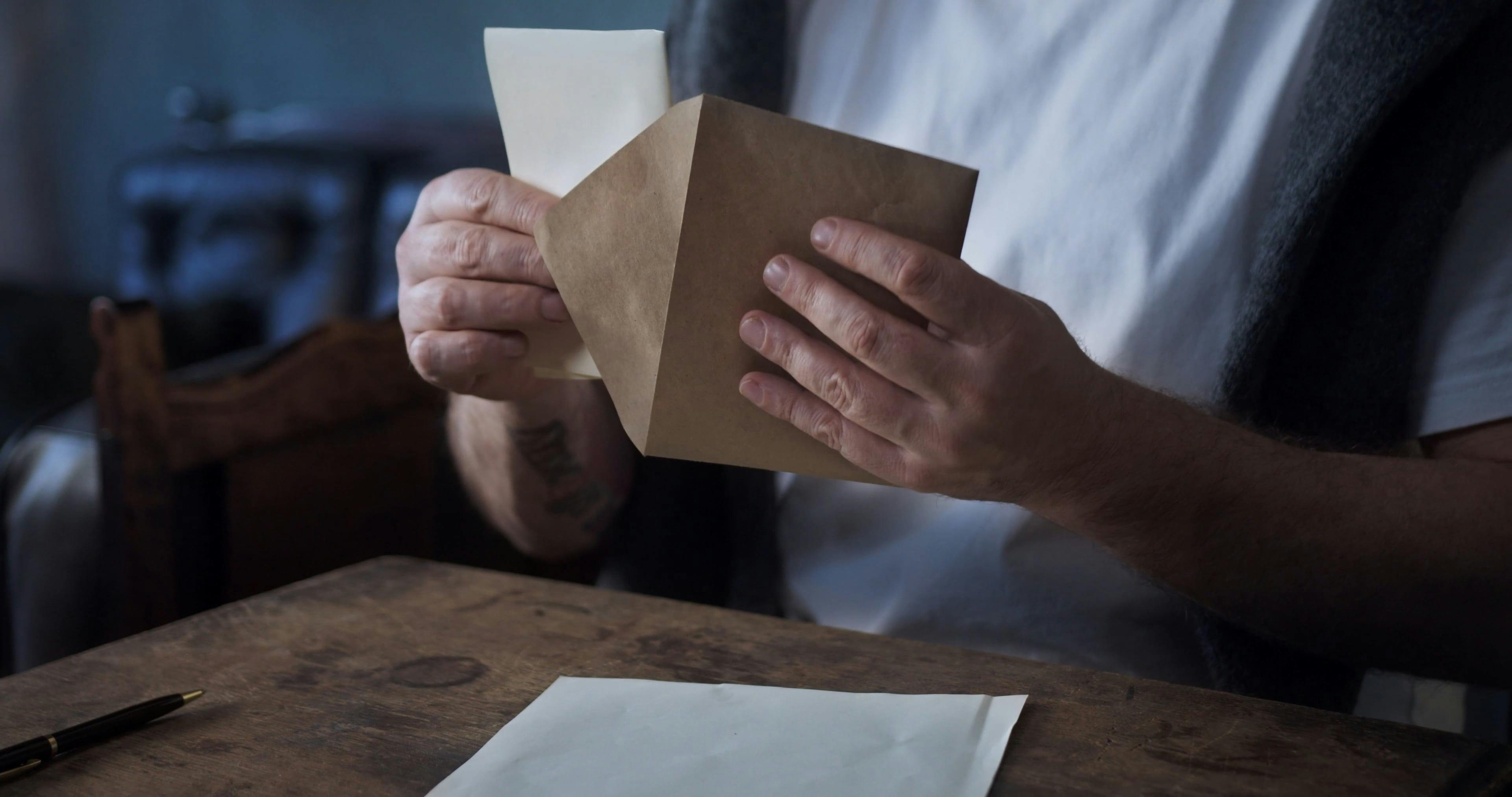 An Elderly Man Putting a Letter in an Envelope · Free Stock Video