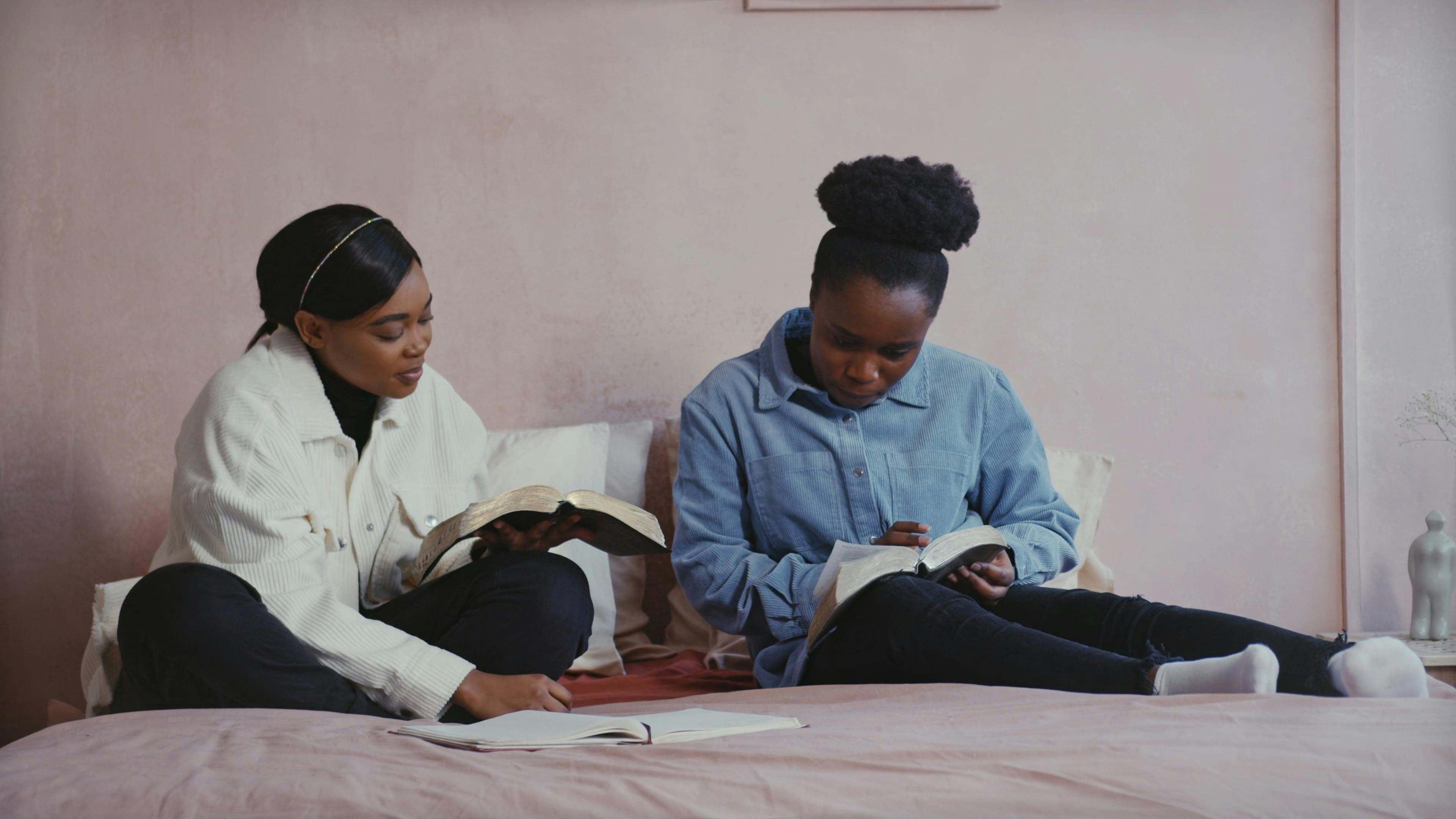 Young Women Reading Books While Sitting On The Bed · Free Stock Video