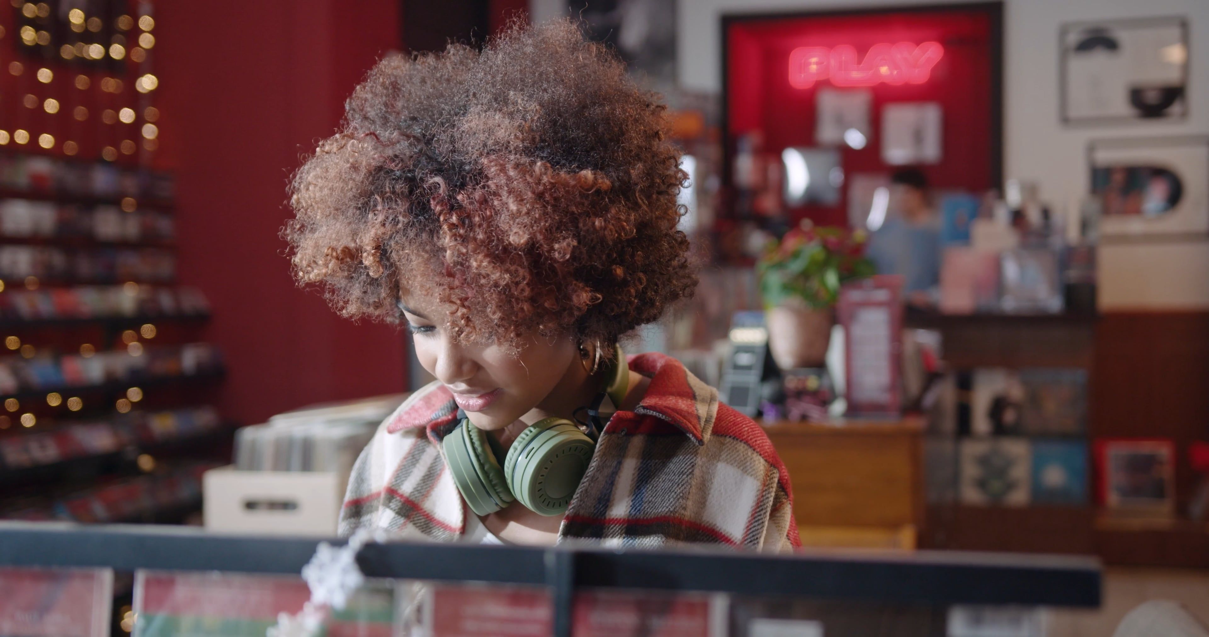 A Store Clerk Looking at a Woman Browsing at a Record Store Free Stock ...