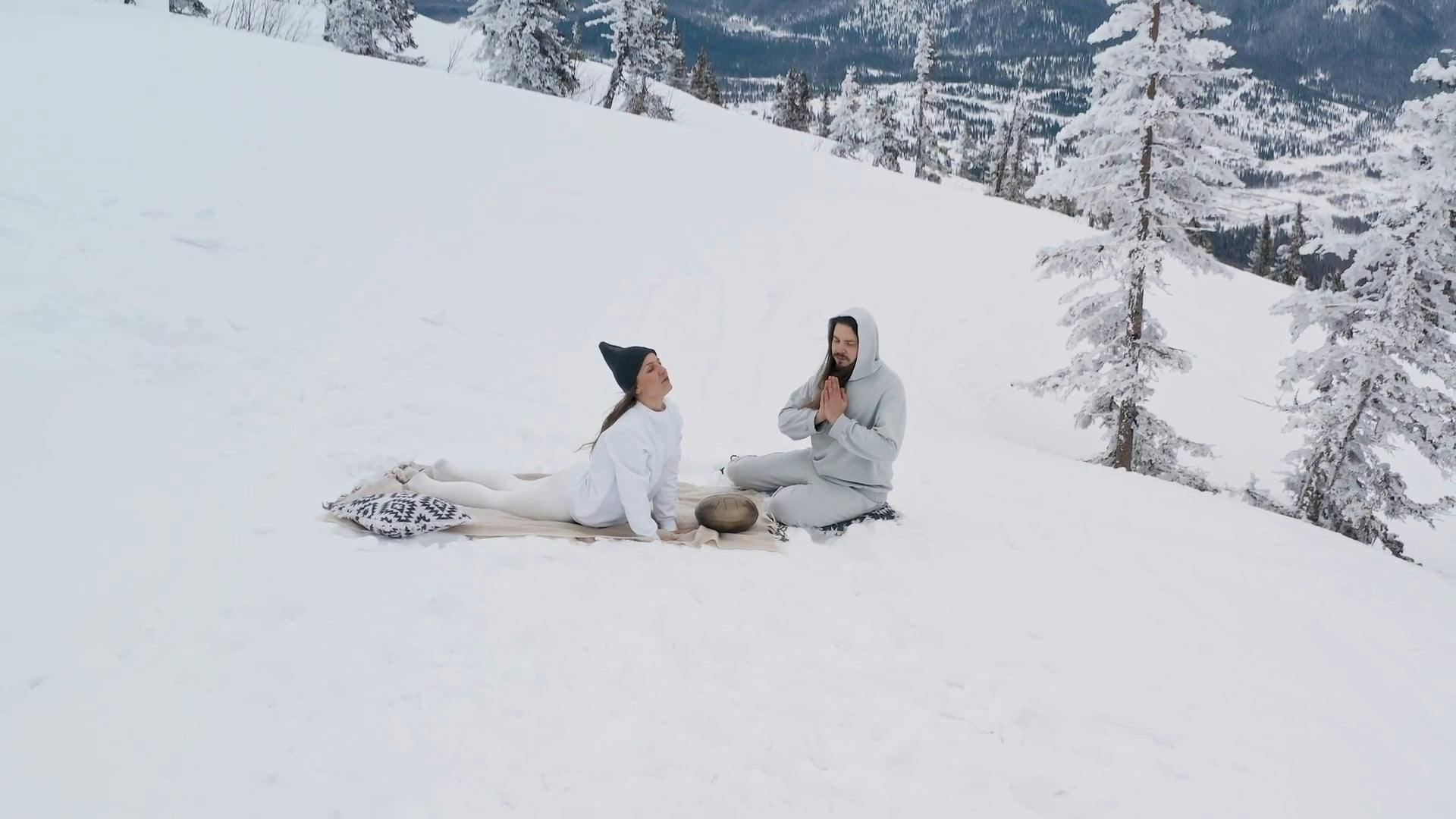 A Man Praying While a Woman is Stretching on Top of a Snow Covered ...