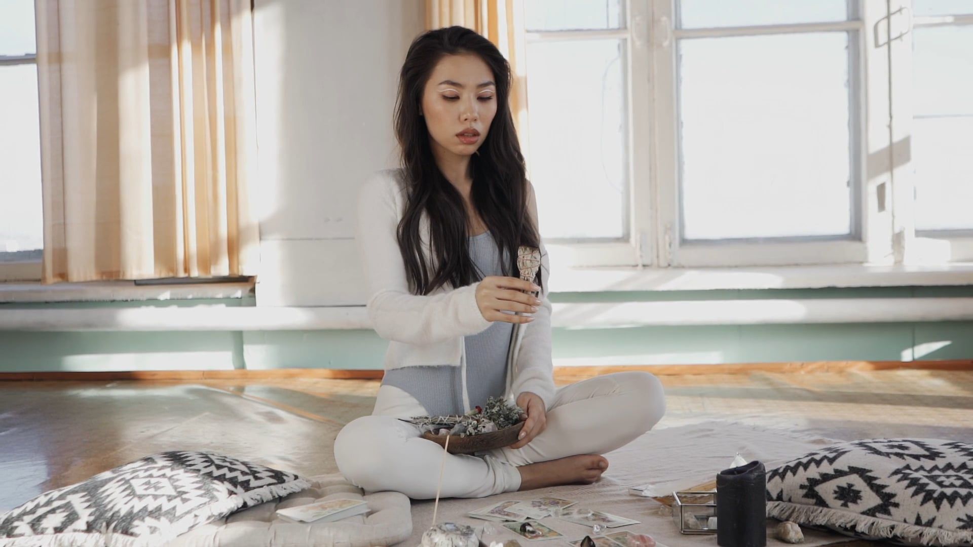 A Woman Sitting on the Floor Holding a Sage Bundle Free Stock Video ...