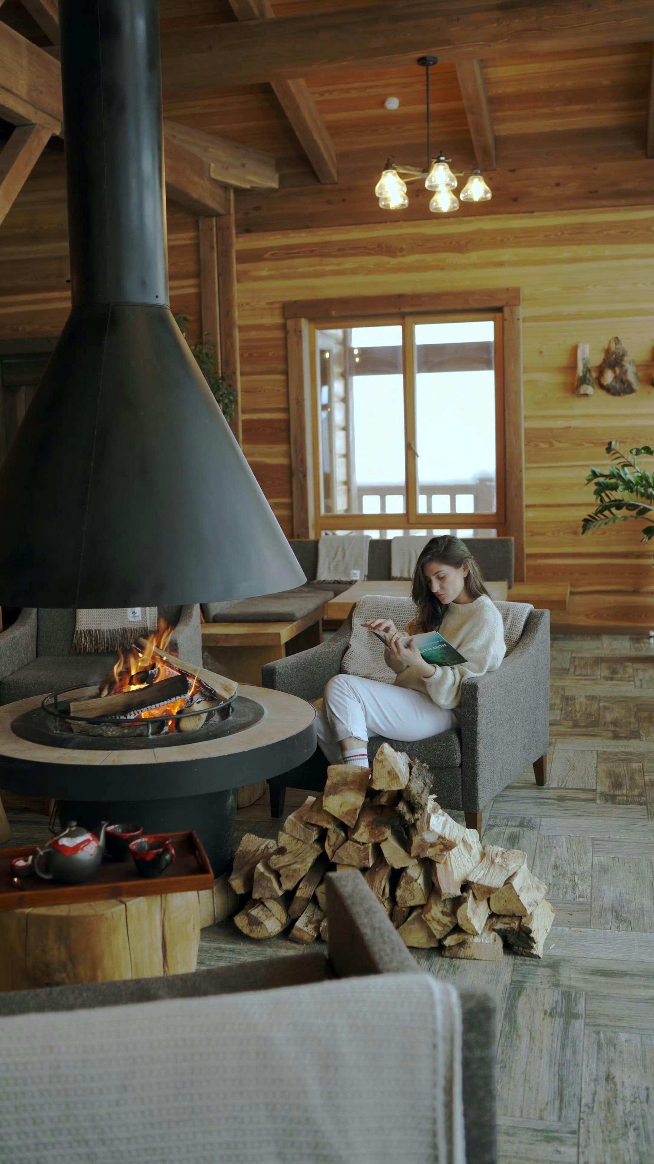 A Woman Reading a Book Near the Indoor Fire Pit Free Stock Video ...