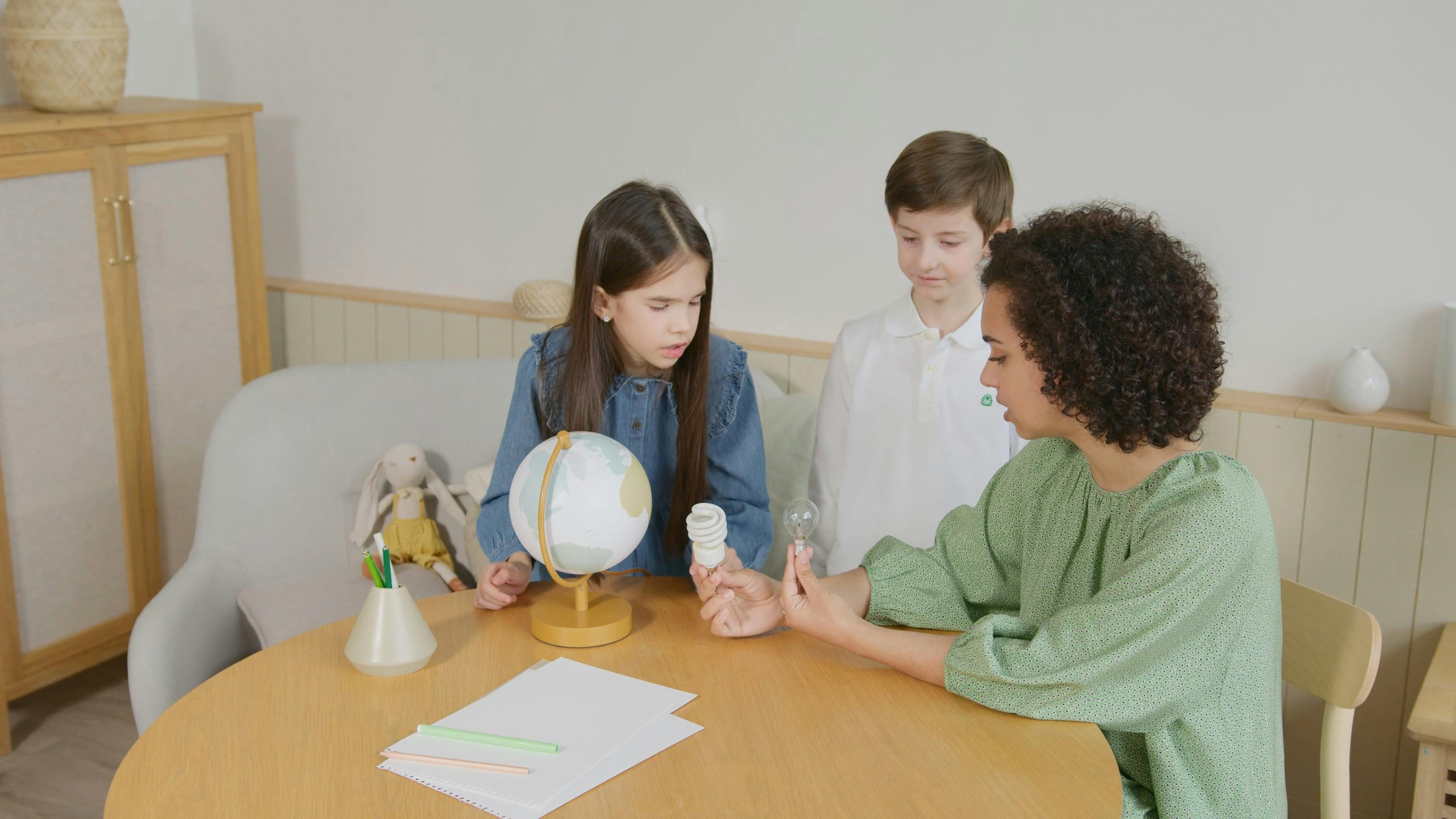 A Child Using A Pencil Writing On A Paper Inside A Classroom · Free ...