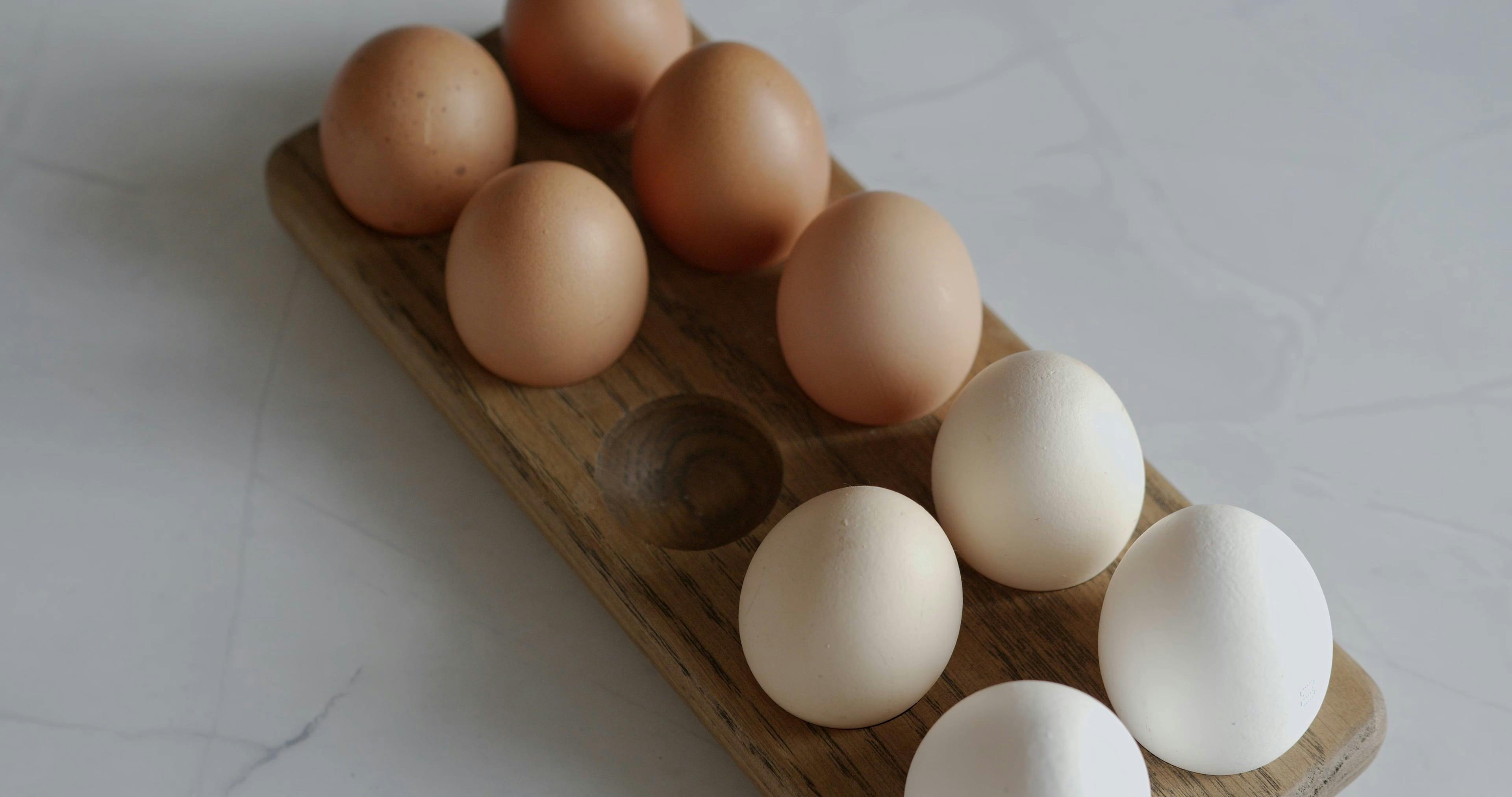 A Person Putting Egg on the Wooden Egg Tray · Free Stock Video