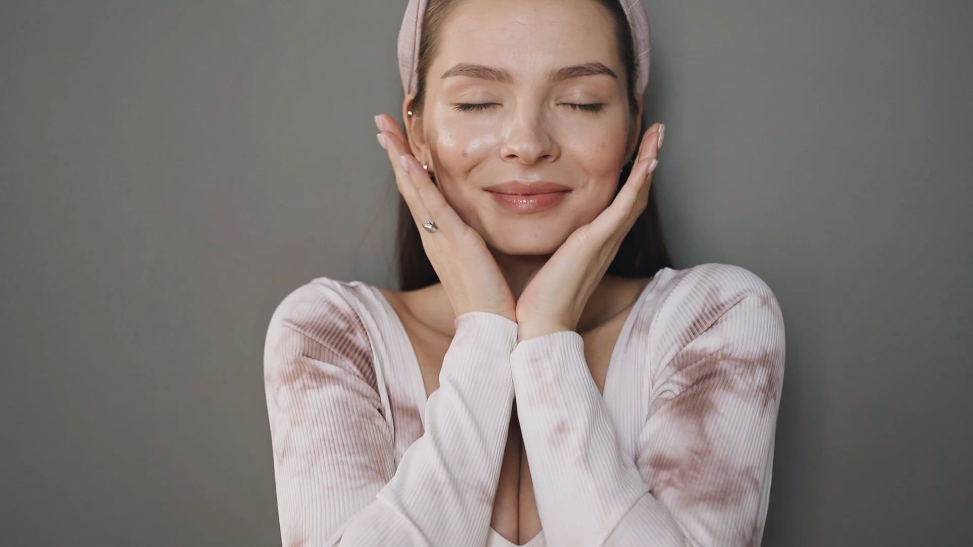 A Woman Looking at a Camera While Patting Her Face Free Stock Video ...