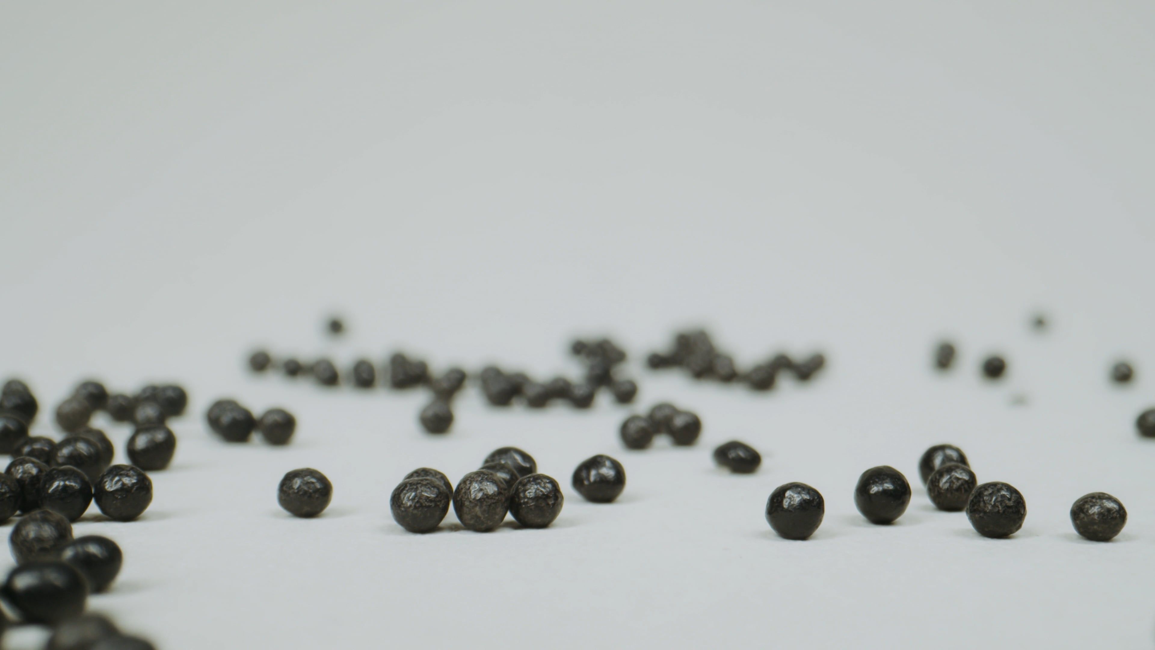 Dropping Black Balls on White Background · Free Stock Video