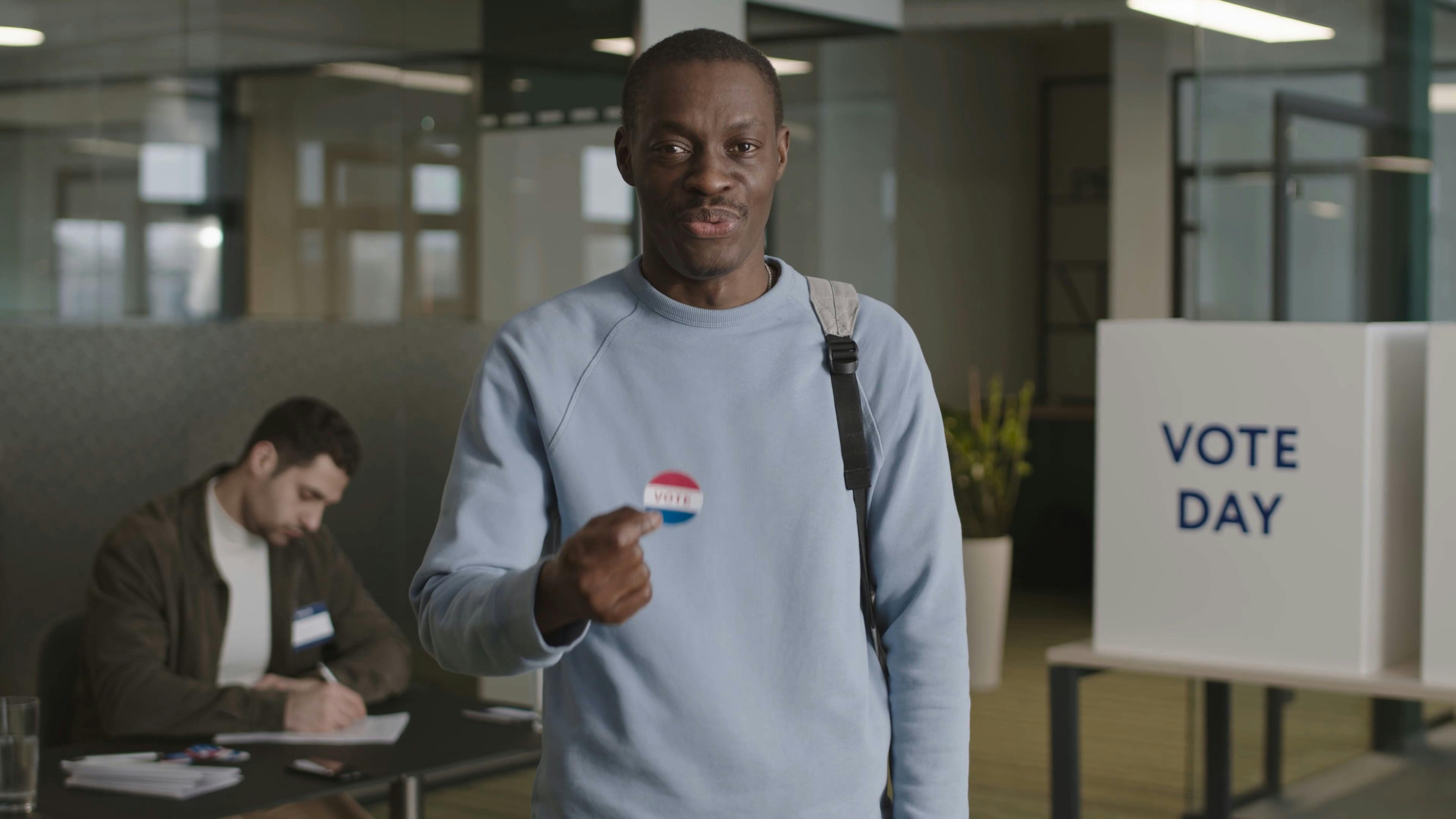 A Man Talking and Holding a Sticker Vote While Looking at the Camera ...