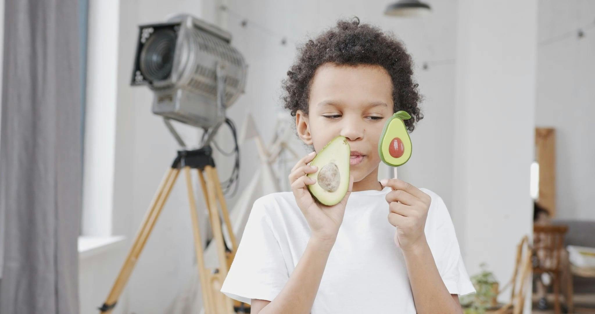A Boy Posing for the Camera While Holding Avocados Free Stock Video ...